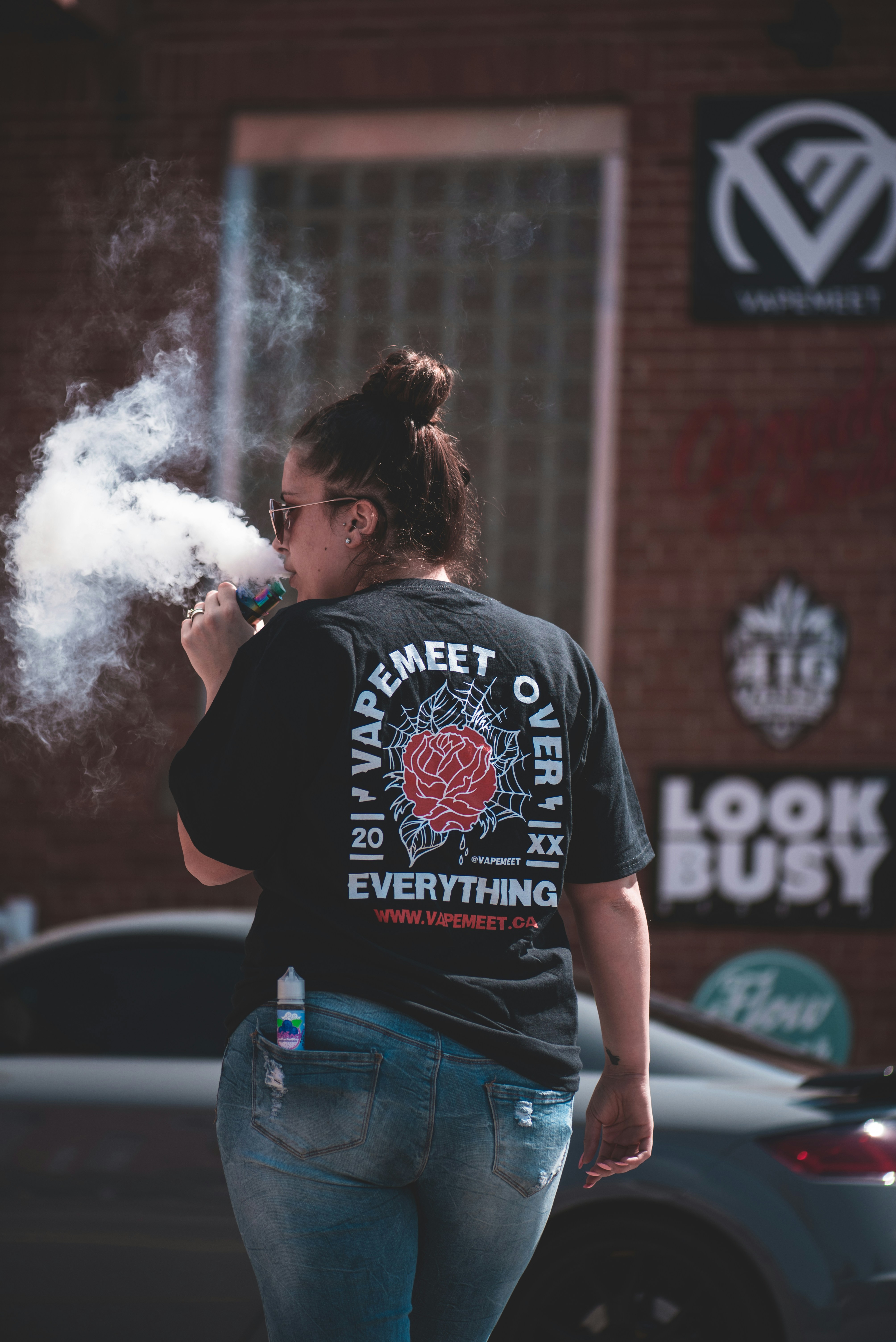 A woman smoking a cigarette in front of a building photo – Free Grey ...