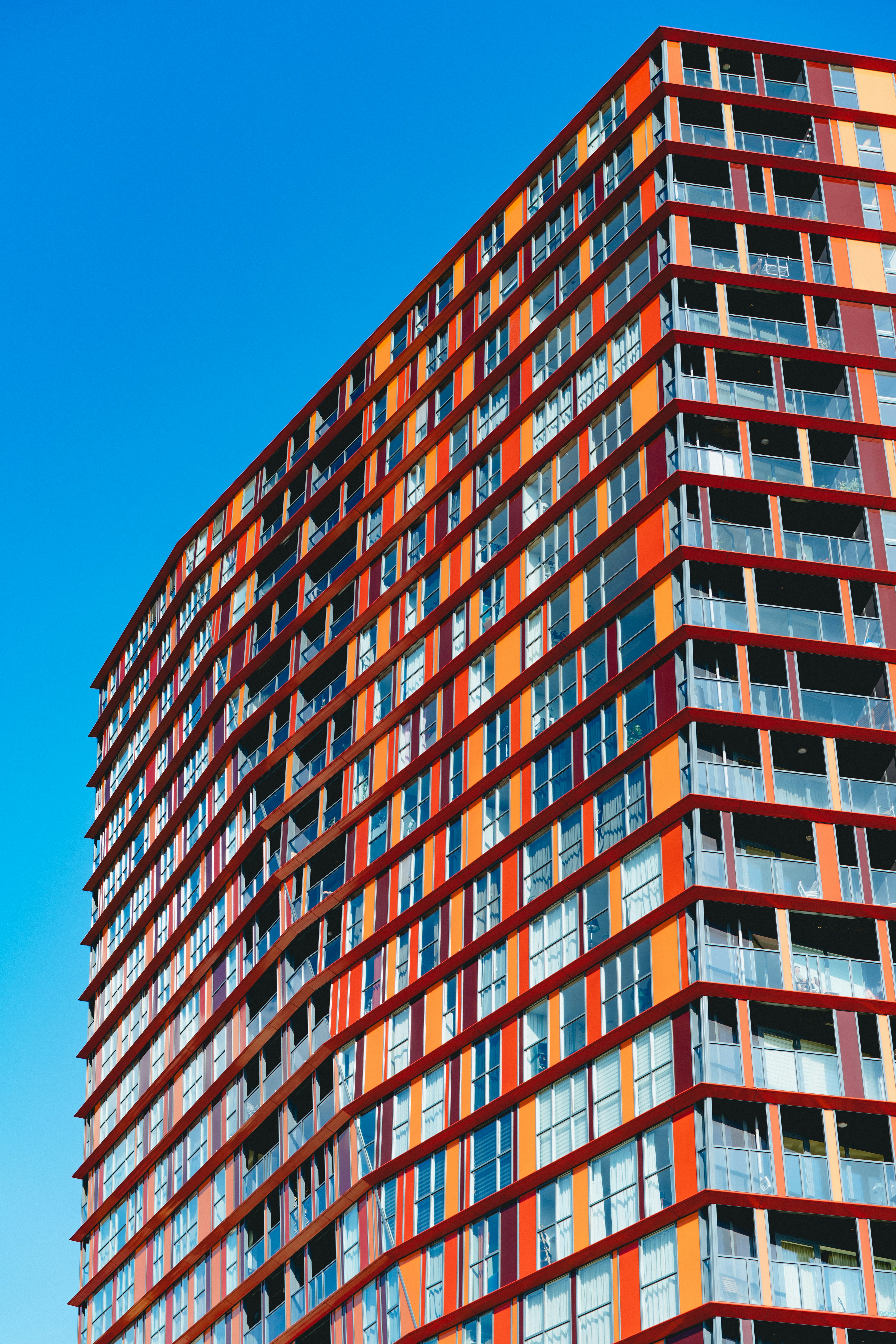 Colorful modern building facade with geometric patterns against a bright blue sky.