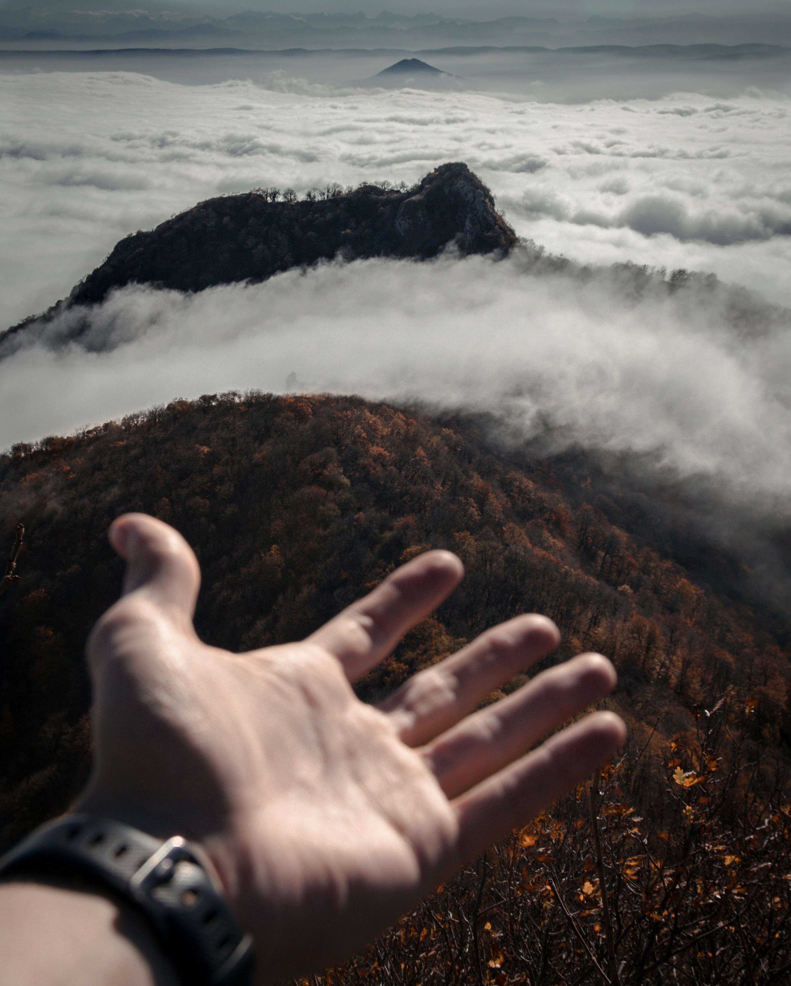 Reach Toward the Cloud-Wrapped Peak: Hand Framing the Horizon