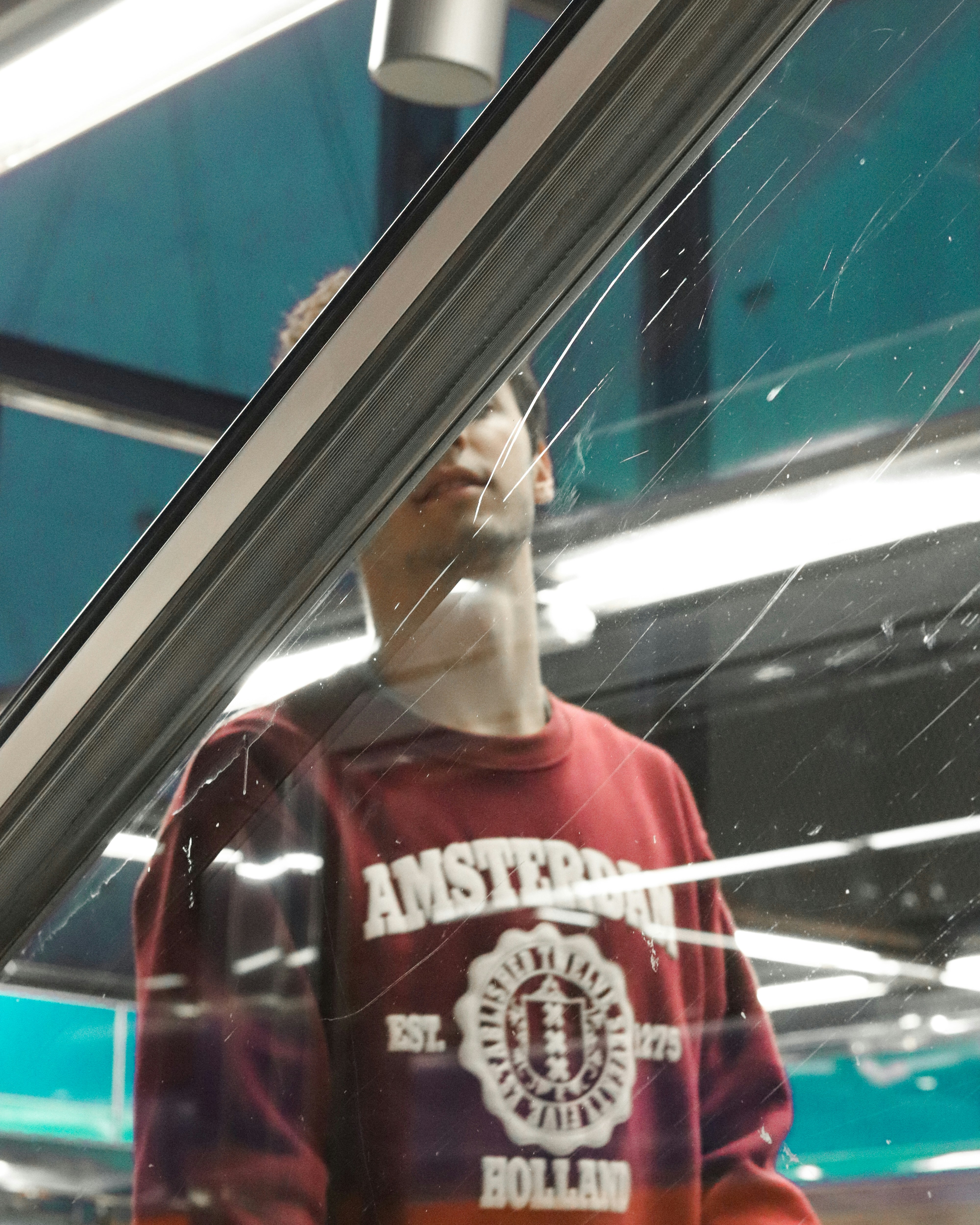 Portrait Through a Diagonal Pane: Youth in a Workshop Glow