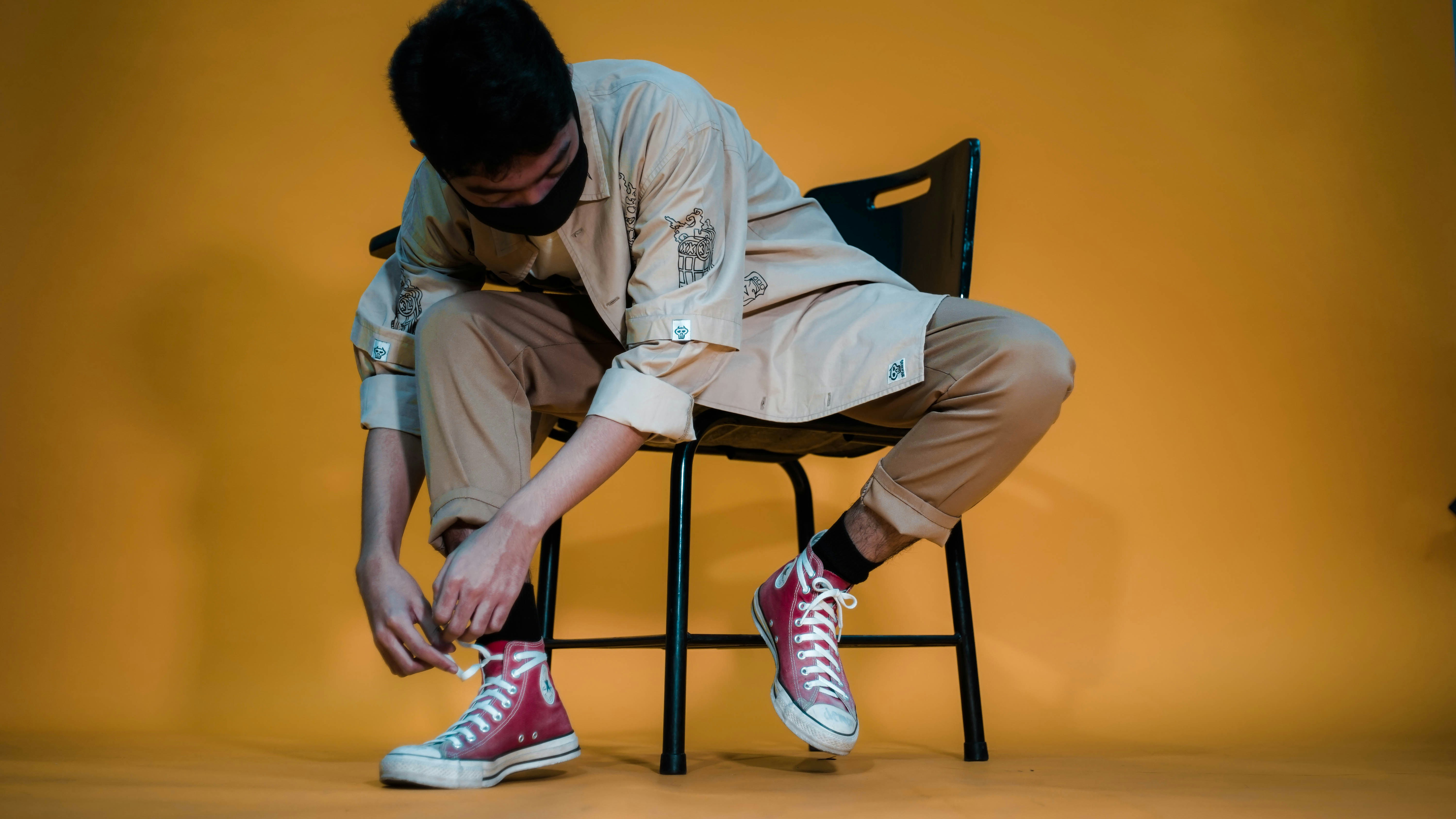 man in brown pants tying his shoes