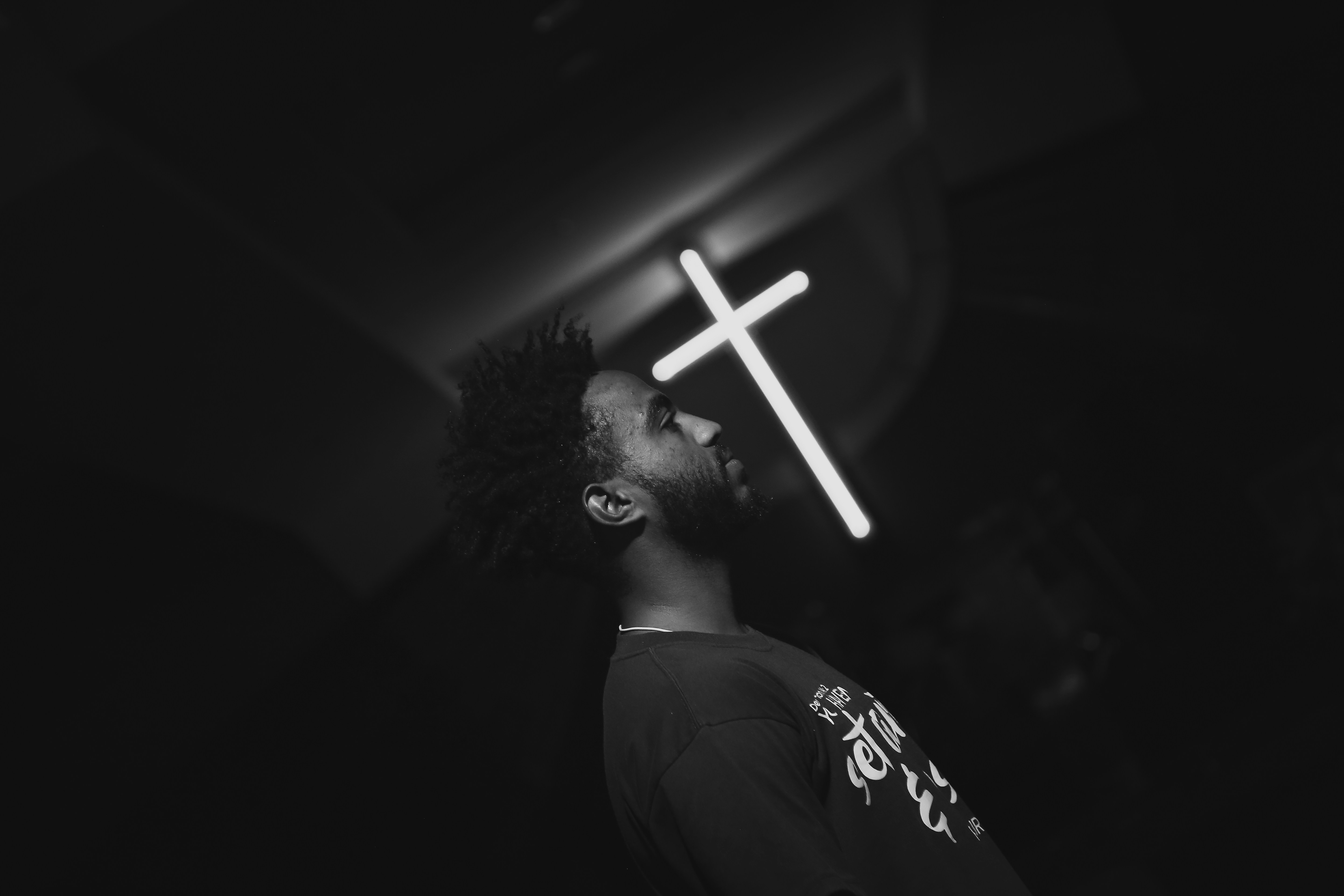 Neon Cross and Quiet Profile: A Monochrome Moment Beneath the Glow
