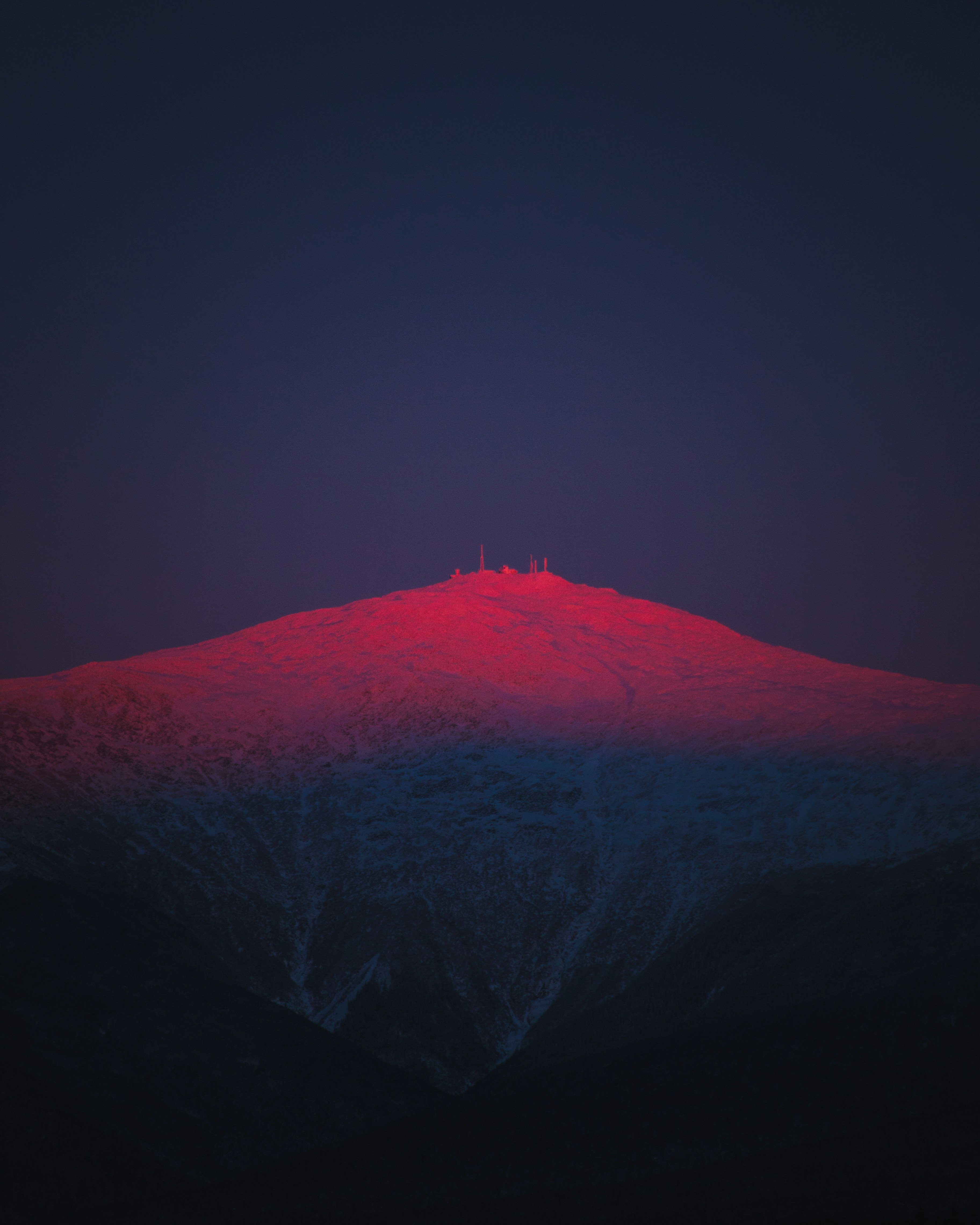 A mountain with a red light on top of it photo – Free Sunset Image on ...
