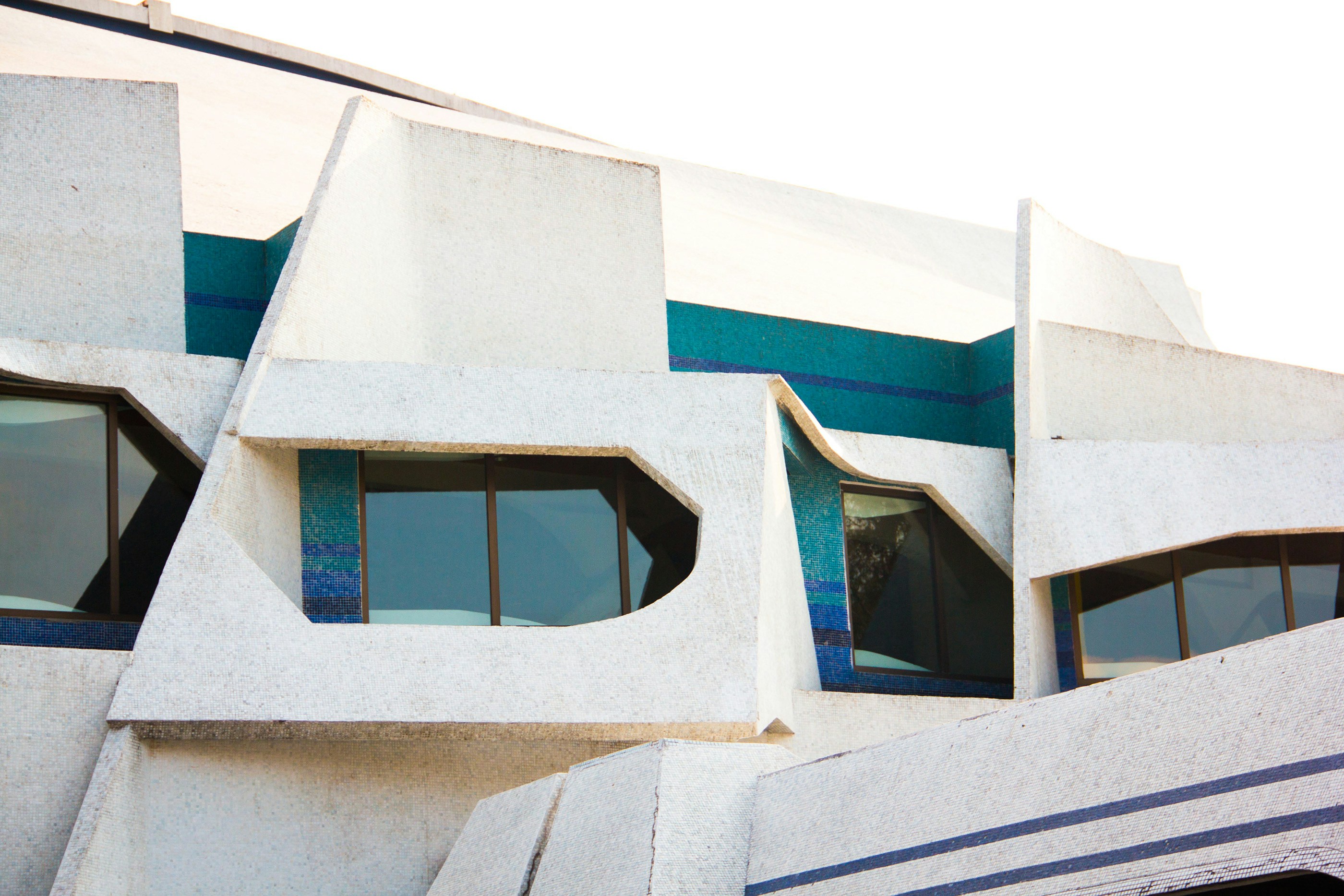 Modern architectural facade with angular windows and blue accents.