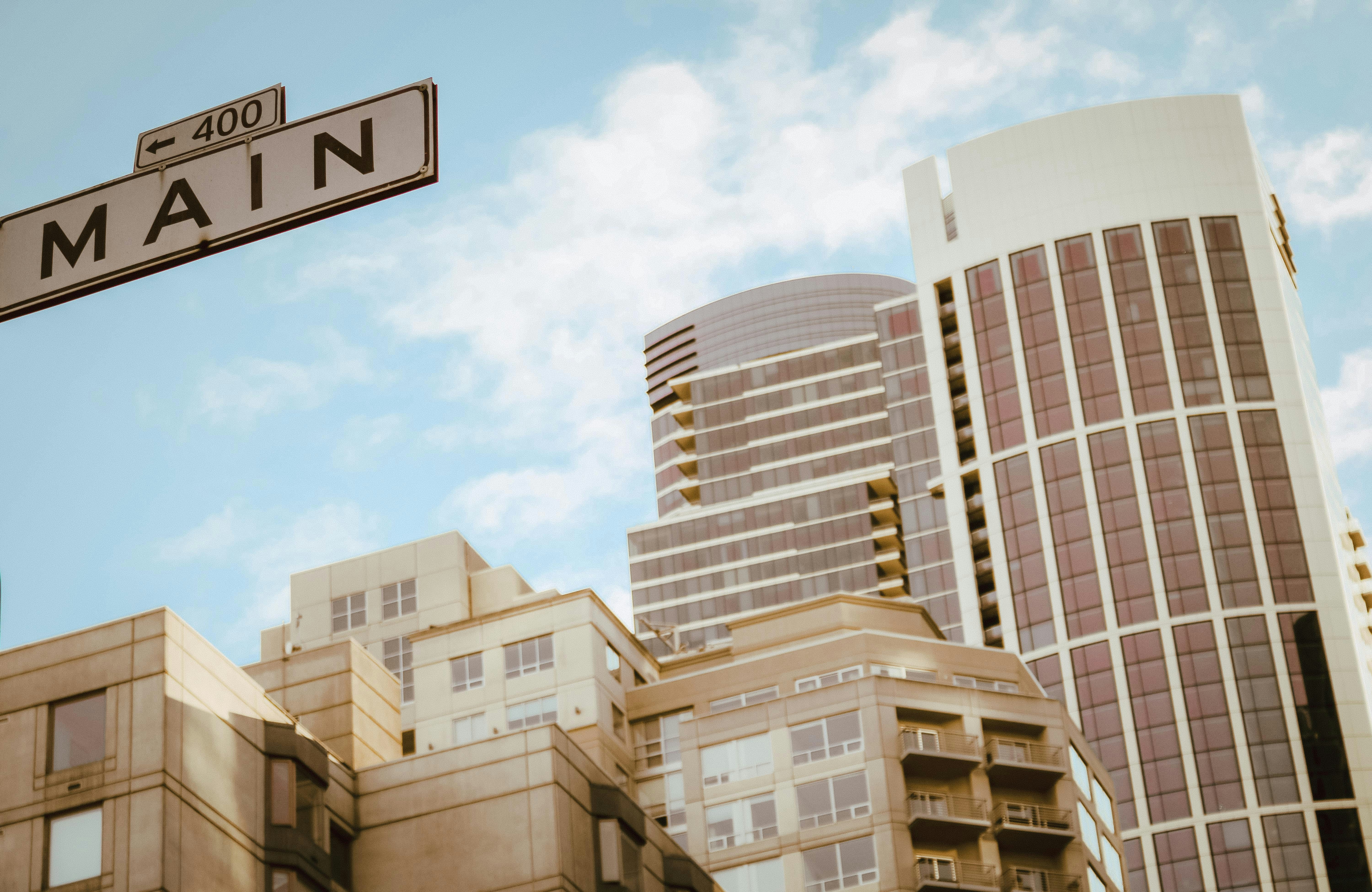 Main Sign Anchors a Quiet City Rising: Concrete Towers Beneath a Clear Sky