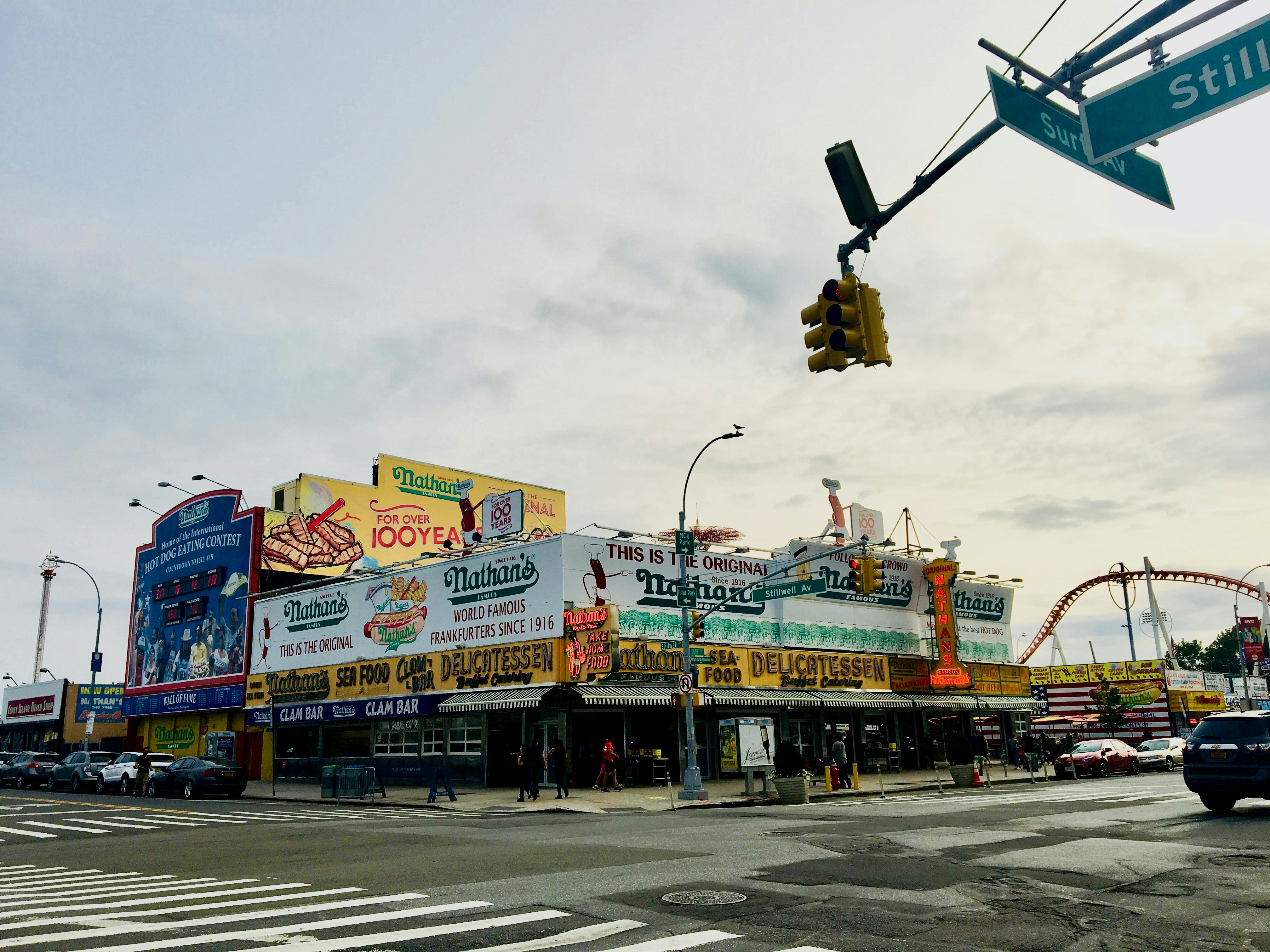 Neon Promenade: A Coney Island storefront row under a bright afternoon sky