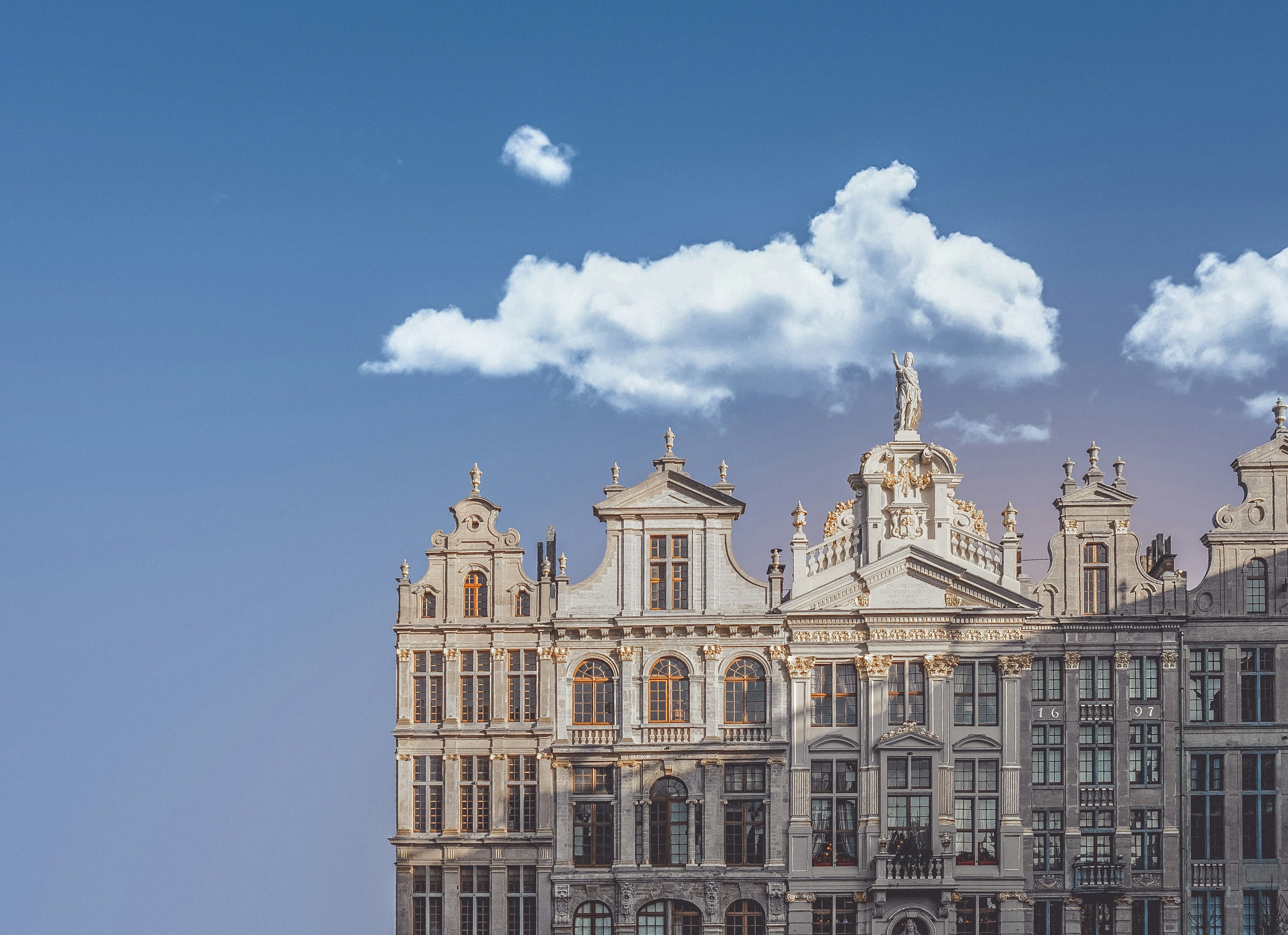 Ornate historic building facade against a clear sky with scattered clouds.