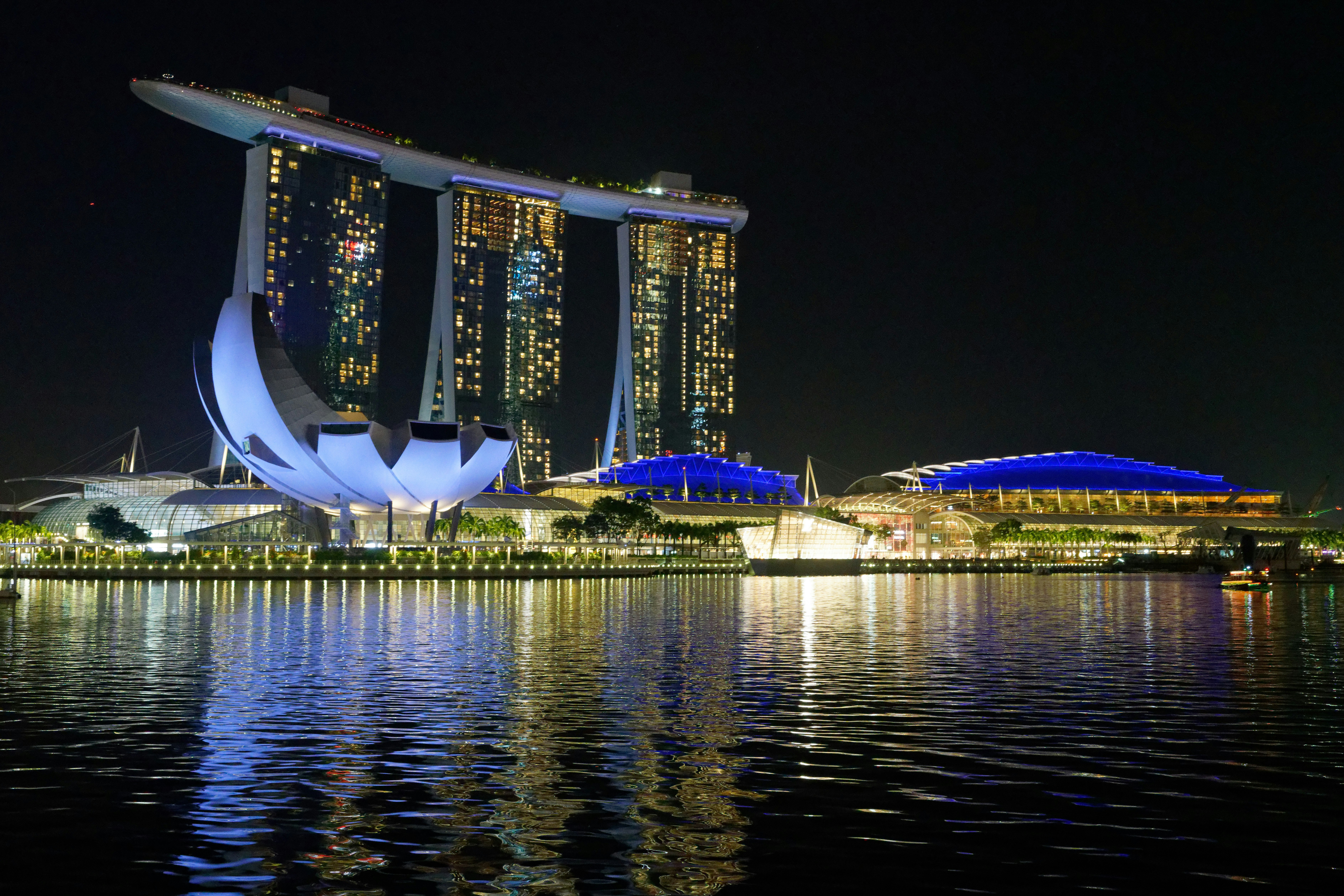 Night view of Marina Bay Sands with vibrant reflections shimmering on calm water.