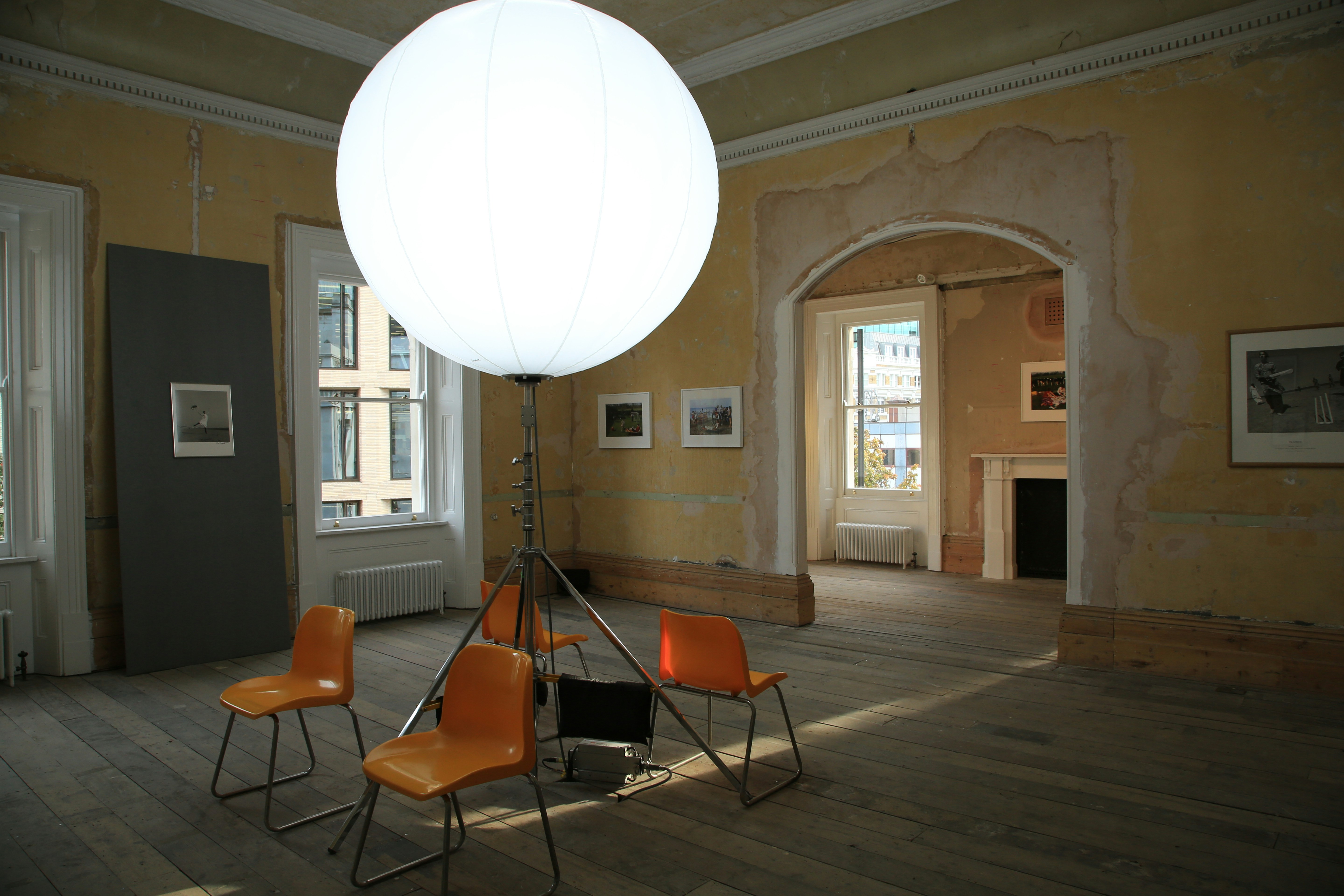 four orange padded chairs in room