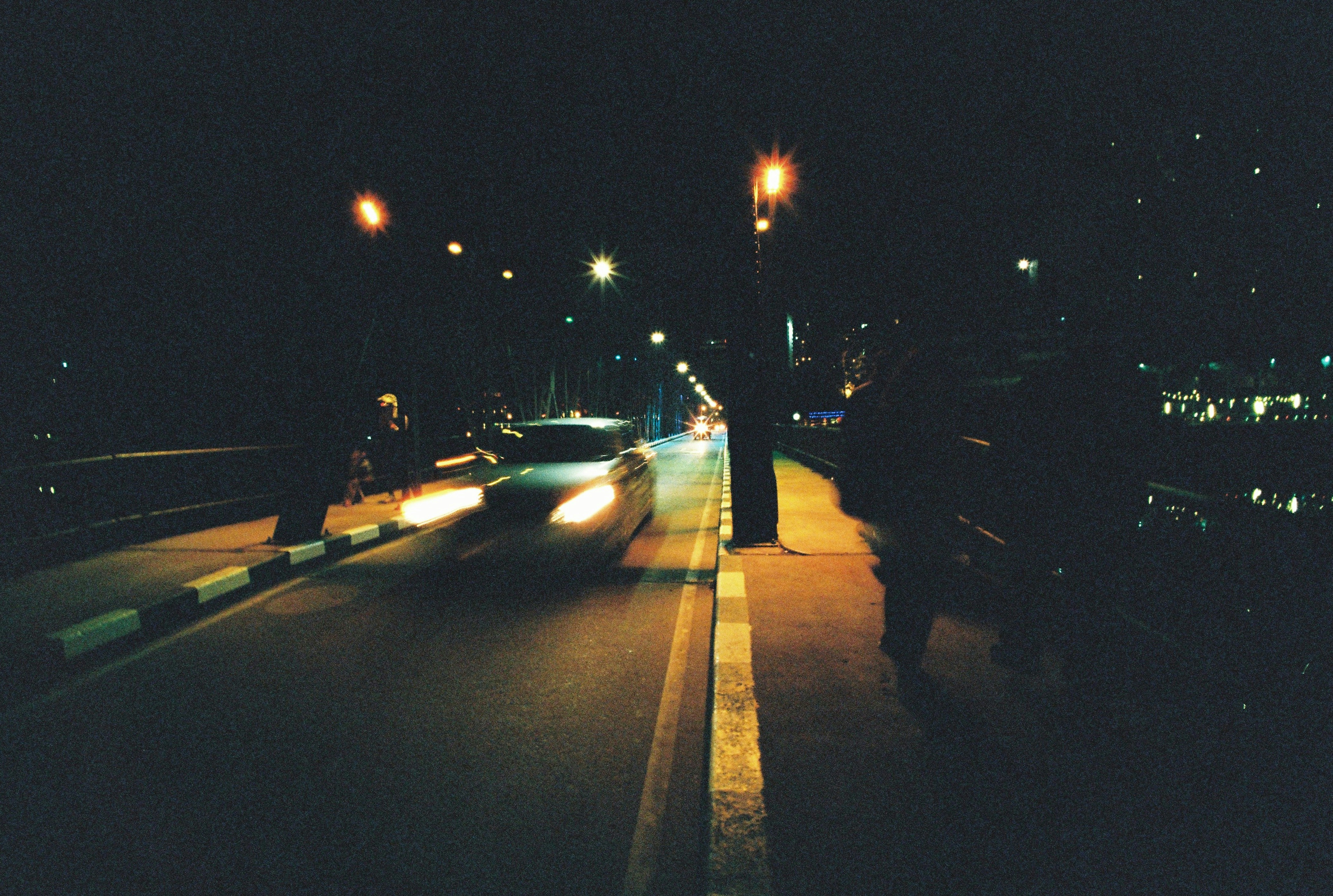 Midnight Riverfront: Headlight Trails Across a Quiet Bridge