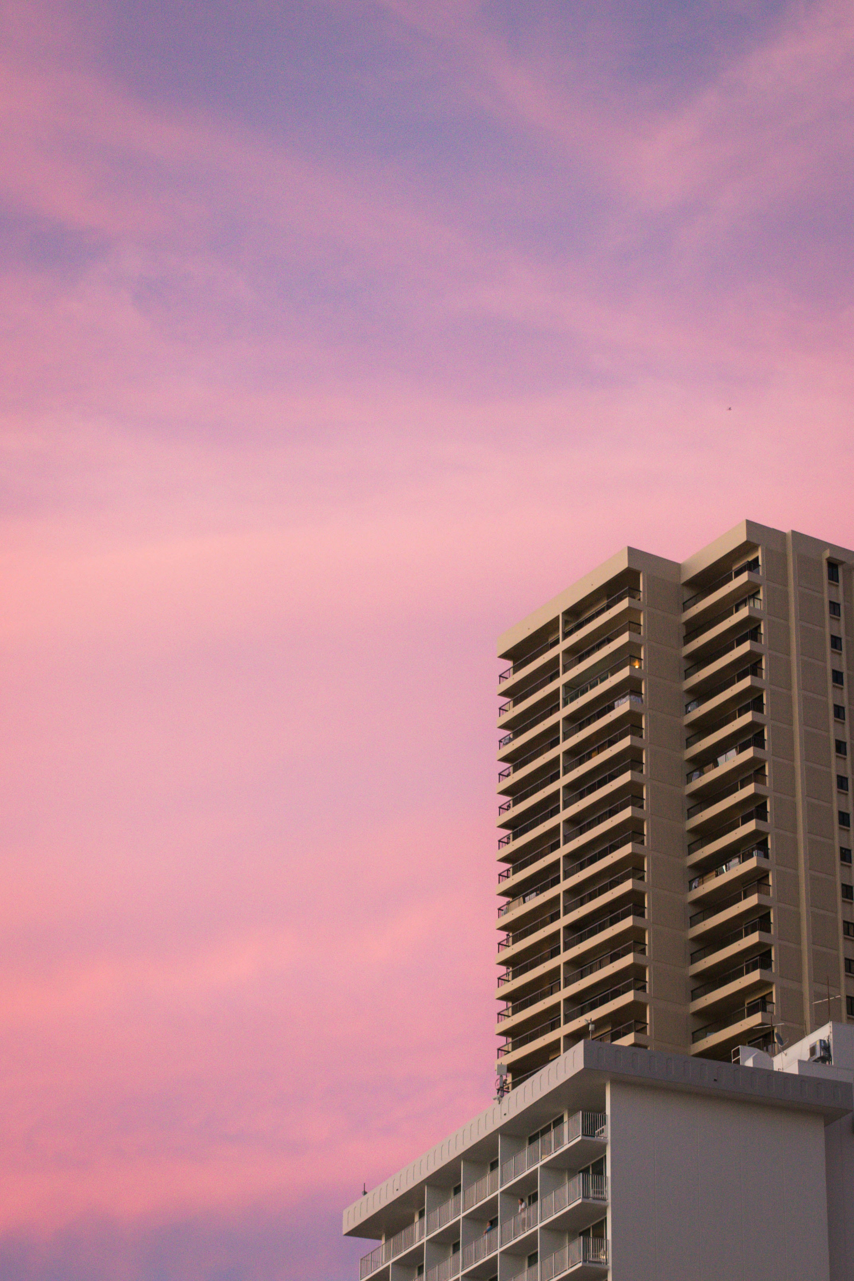 Our first night in Honolulu on vacation we were greeted with the most gorgeous pink sunset I’ve ever seen. | concrete building during sunset