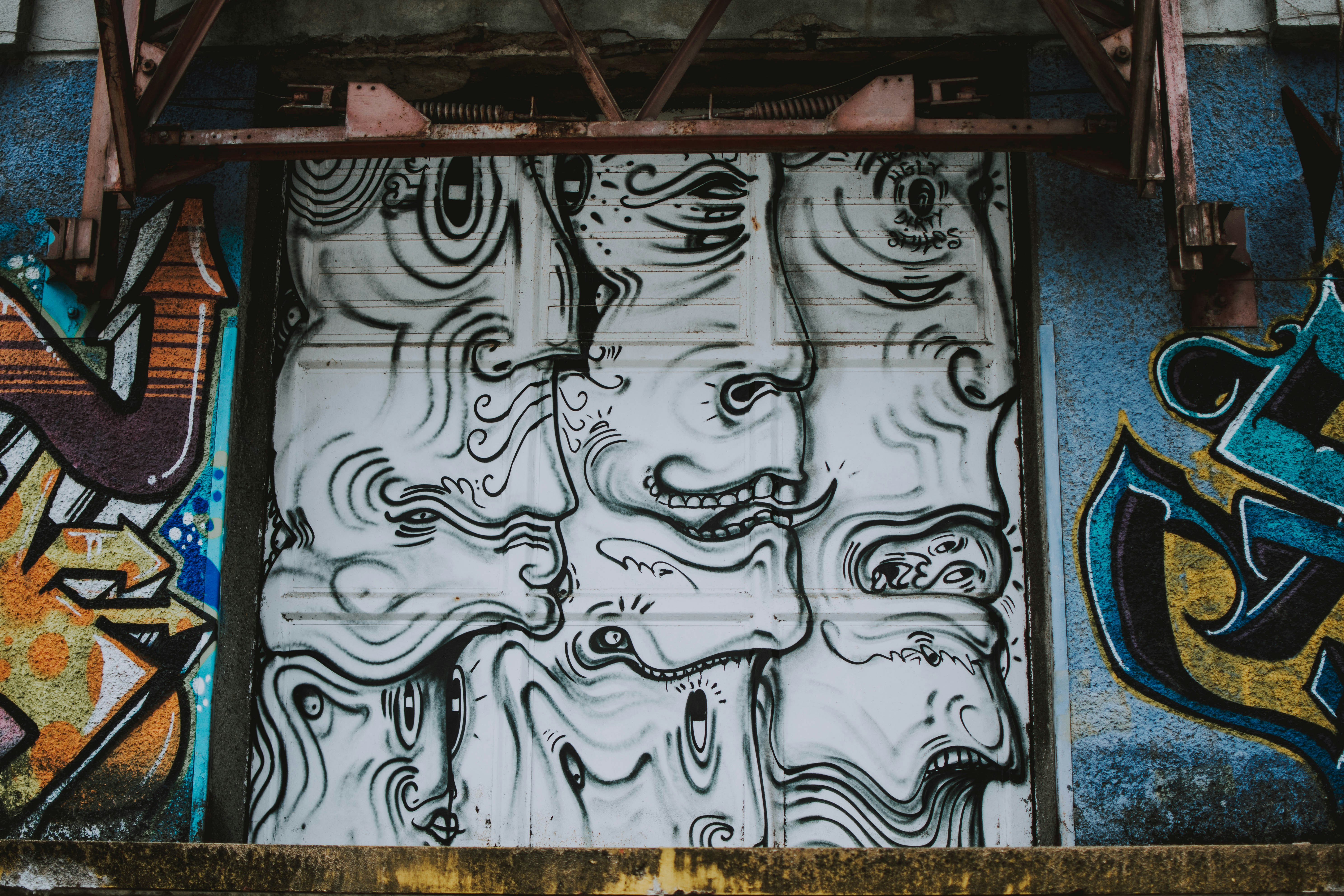 Abstract graffiti with swirling faces on an urban wall.