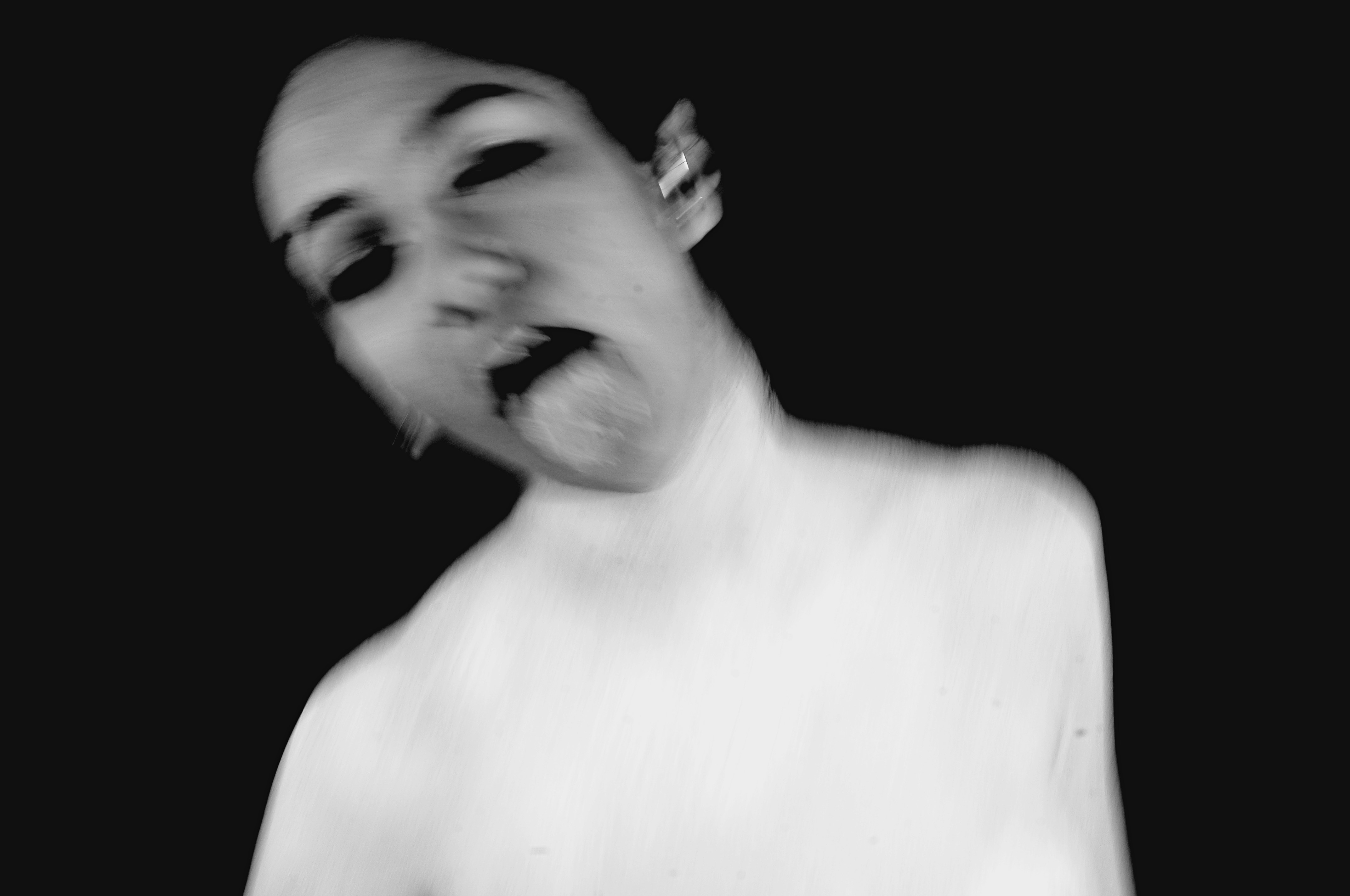 Abstract portrait with intentional motion blur against a black background.