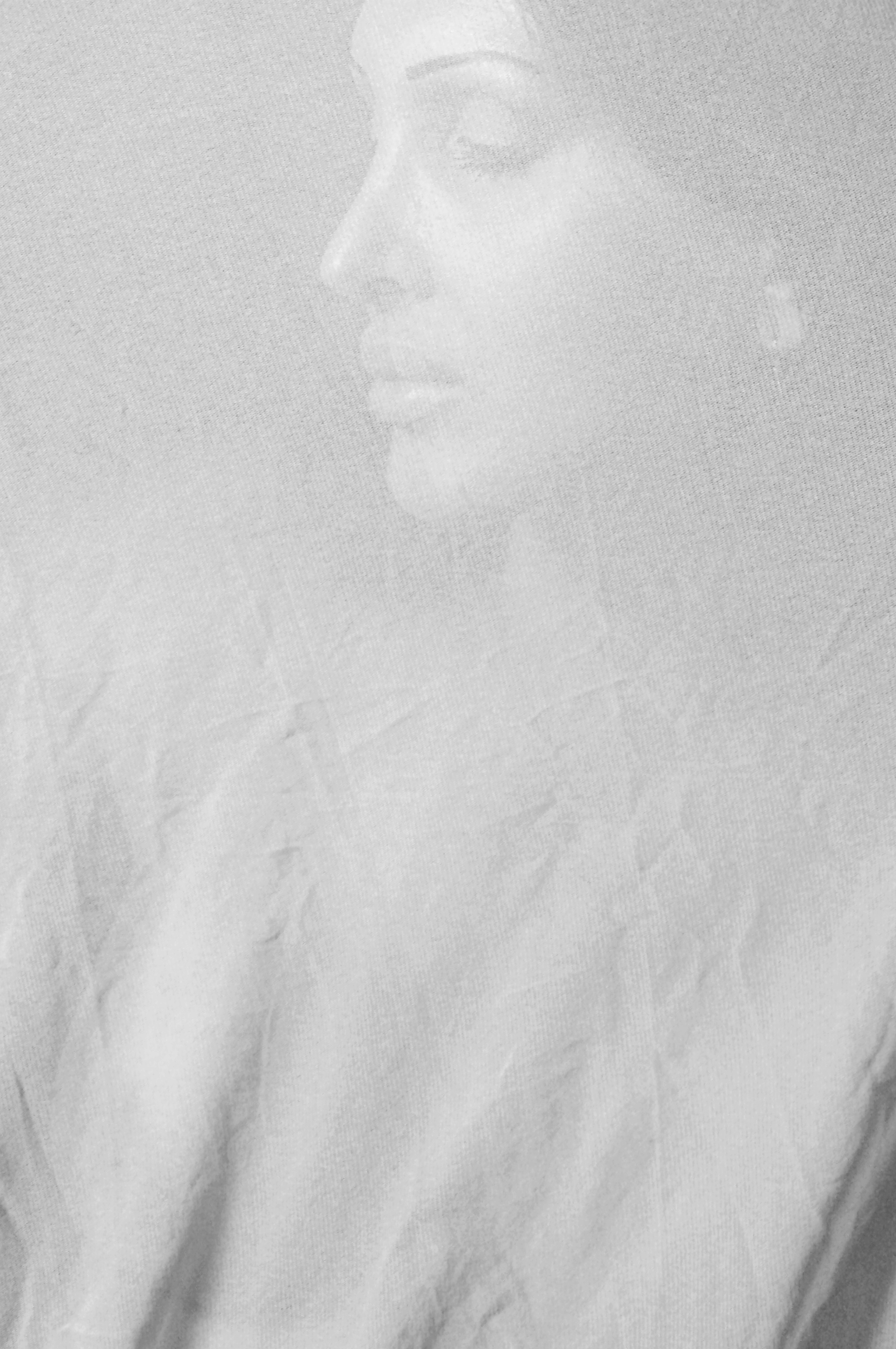 Woman's face subtly visible through sheer fabric, creating a dreamy and ethereal effect.