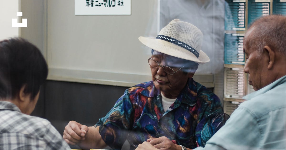 방 안에서 마작을 하는 세 남자가 앉아 있습니다 사진 Unsplash의 무료 오사카 이미지