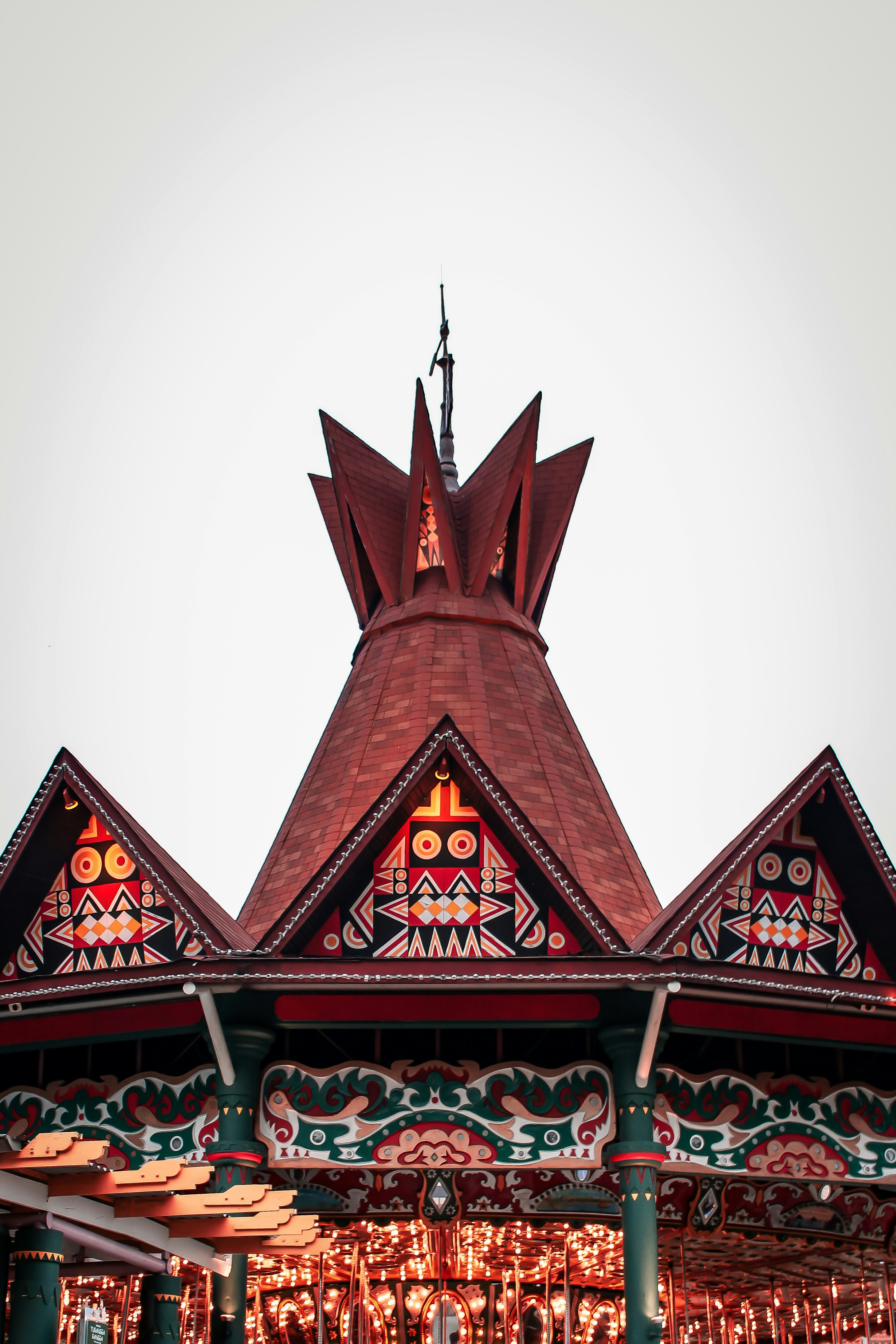 Crimson Spire Rising Over a Carved Carousel Façade
