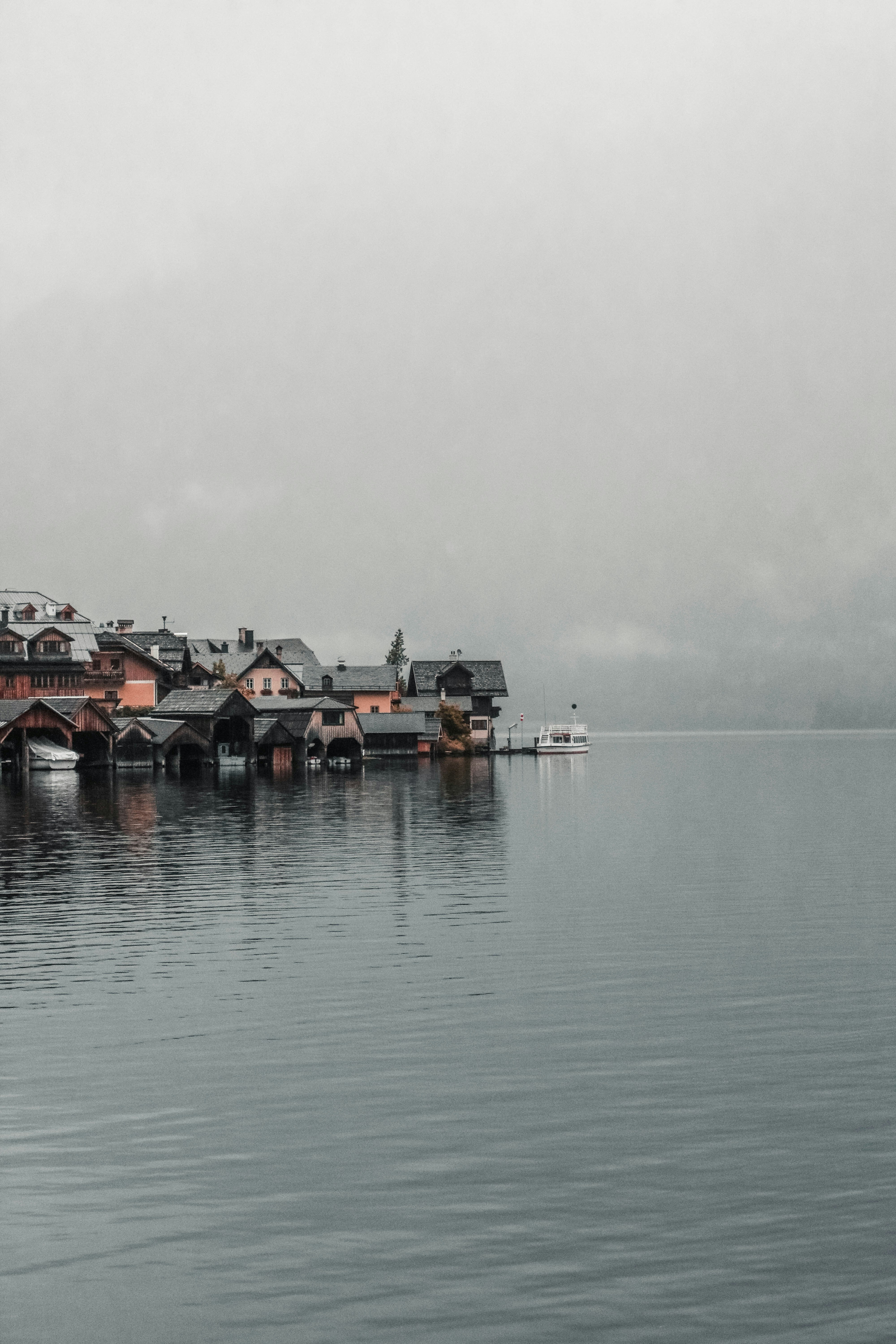 Harbor Haze: Pastel Cottages and a Lone Boat in Quiet Morning Fog