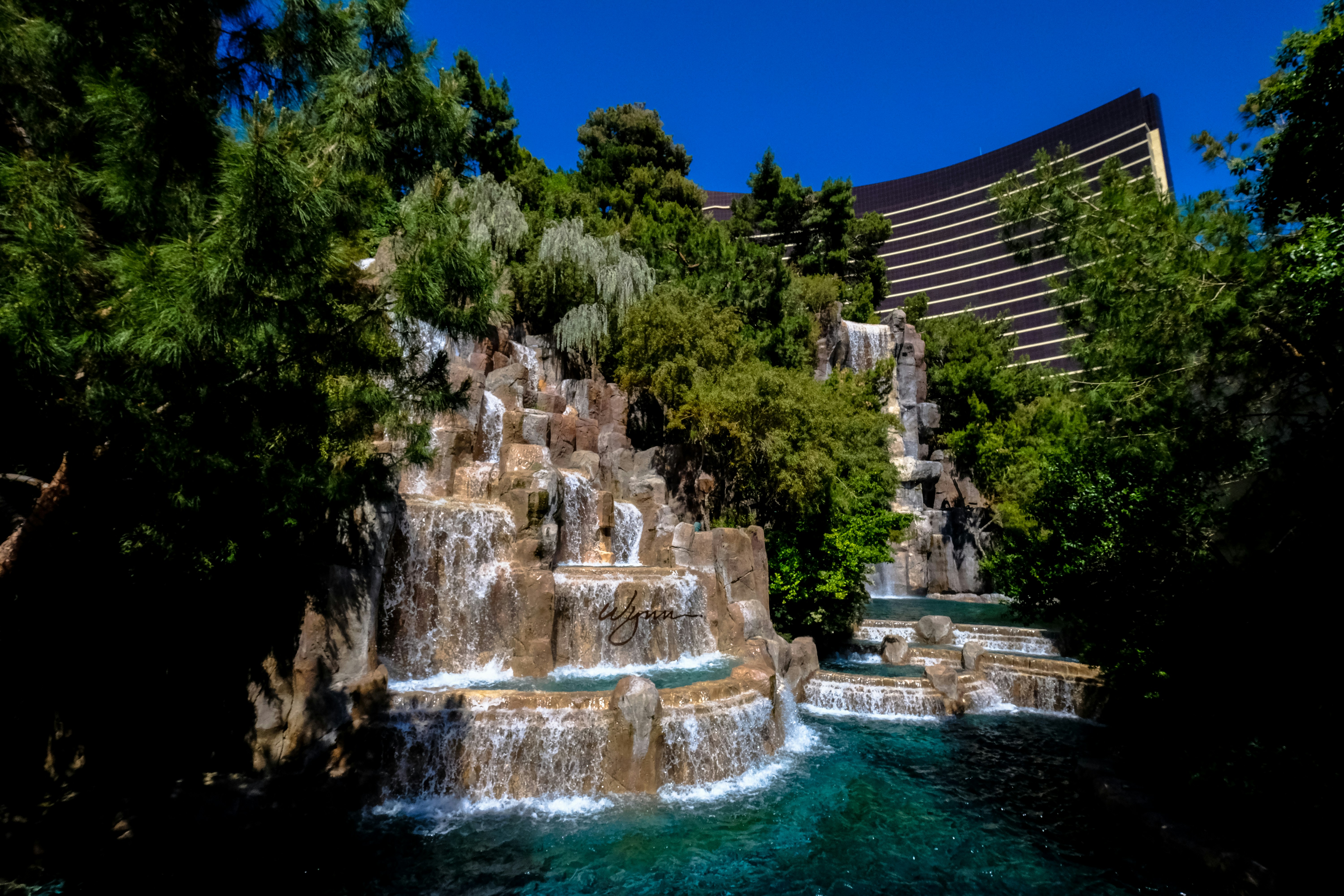 Cascading waterfalls beside building photo – Free Water Image on Unsplash