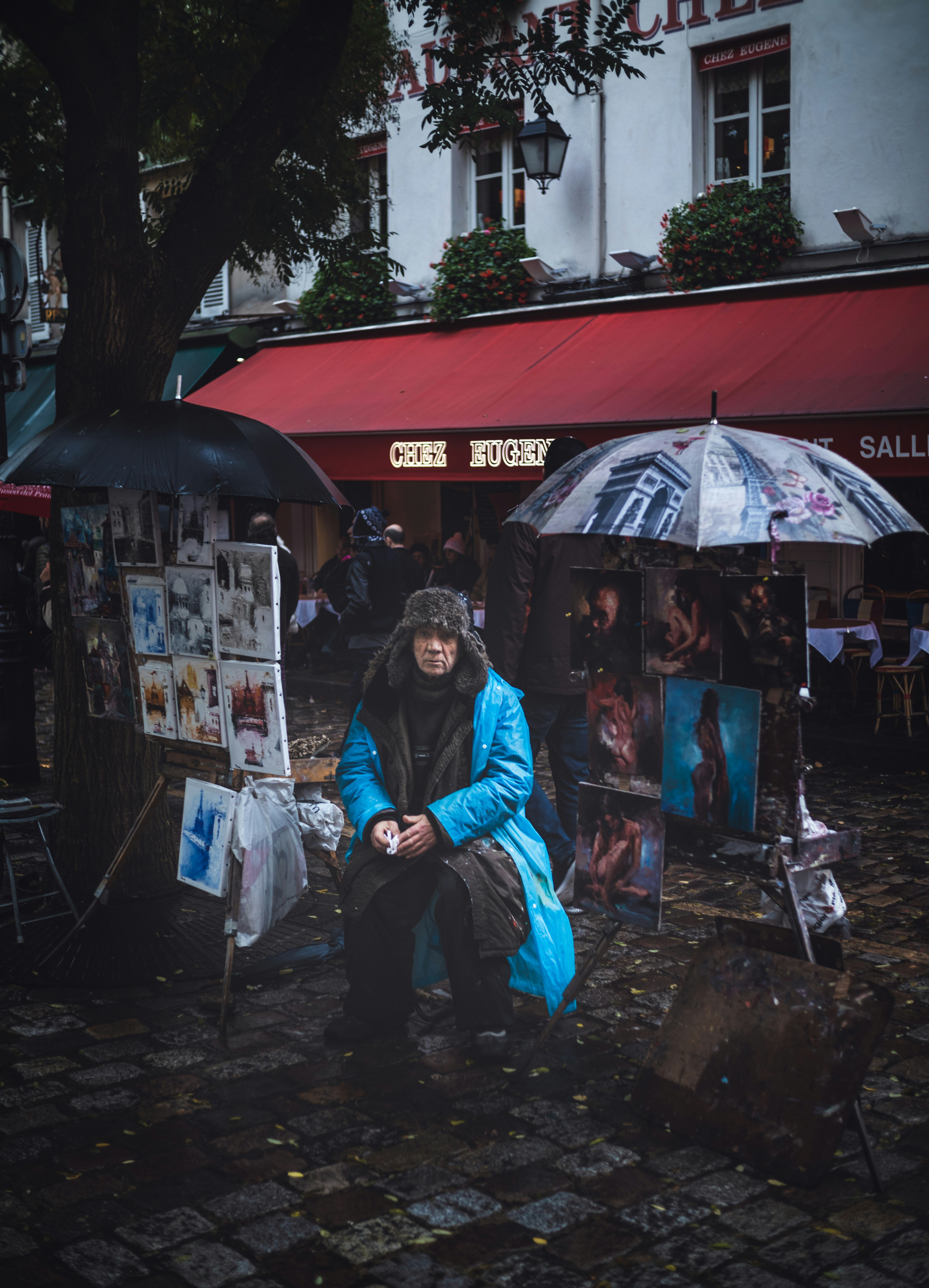 Blue-Clad Vendor Amid Umbrellas in a Rainy Market