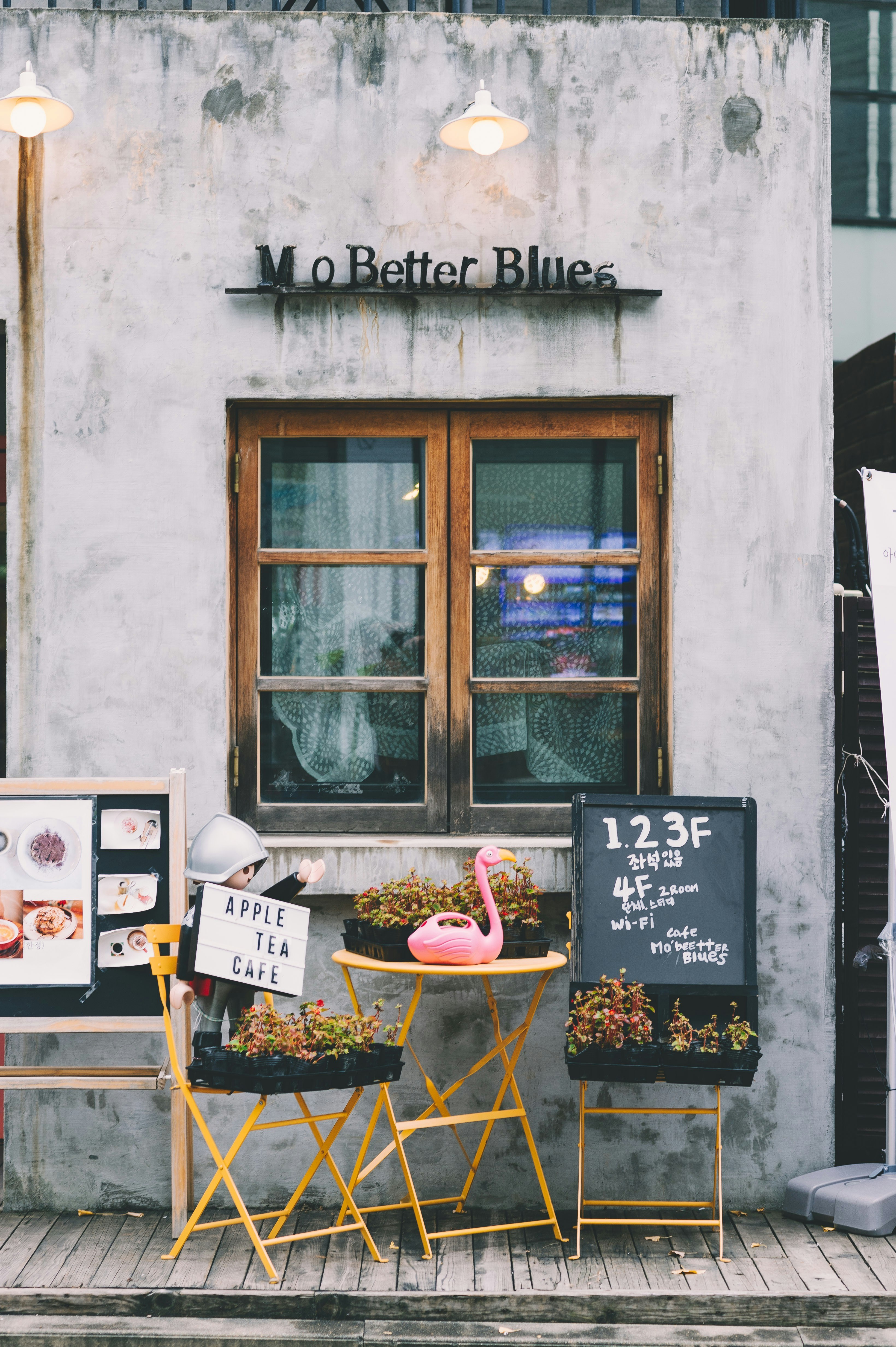 Mo Better Blues Café: Sunlit Corner with Yellow Tables and a Pink Flamingo