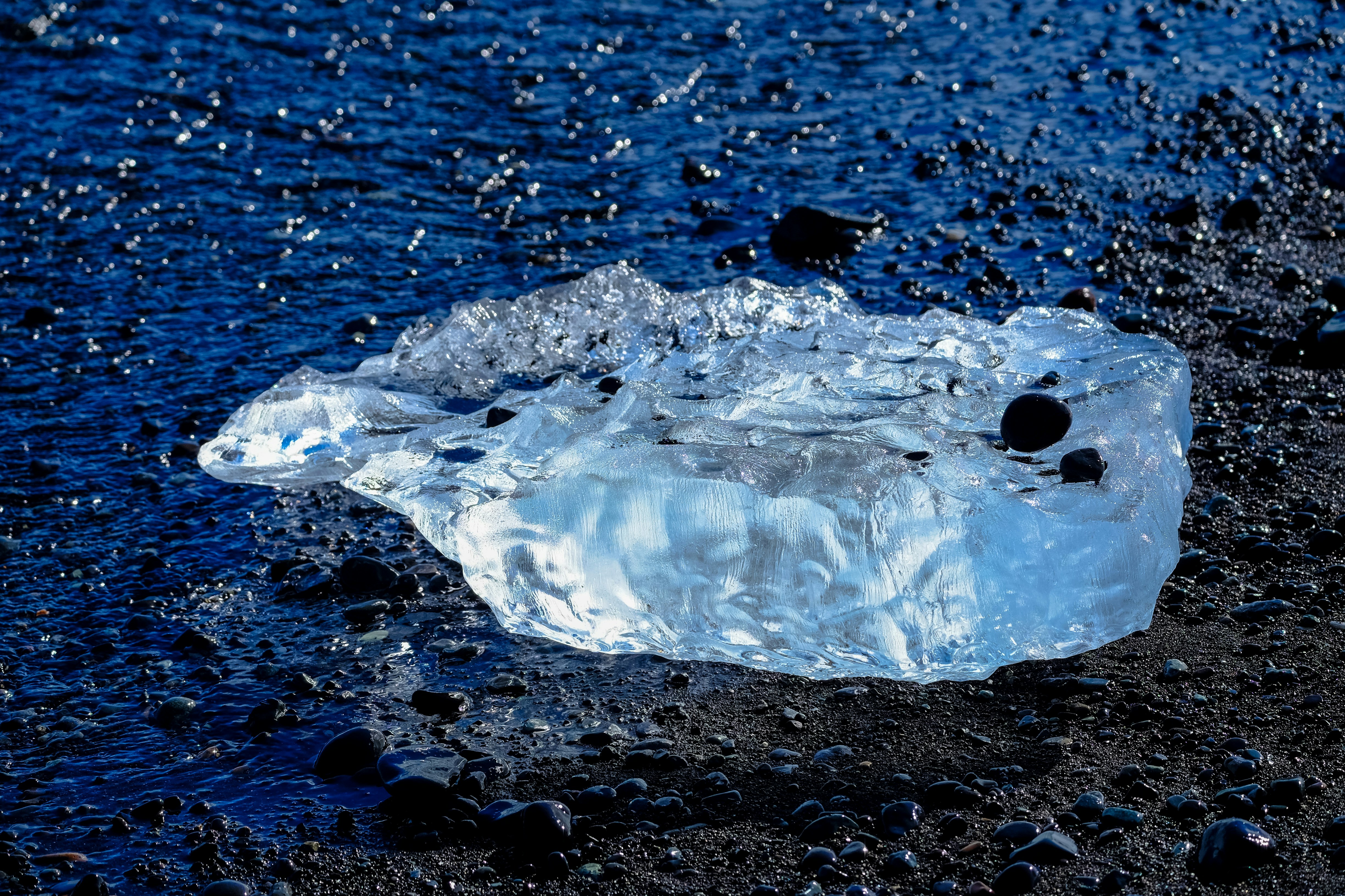 Indigo Shorelight: Ice Fragment on a Pebble Beach