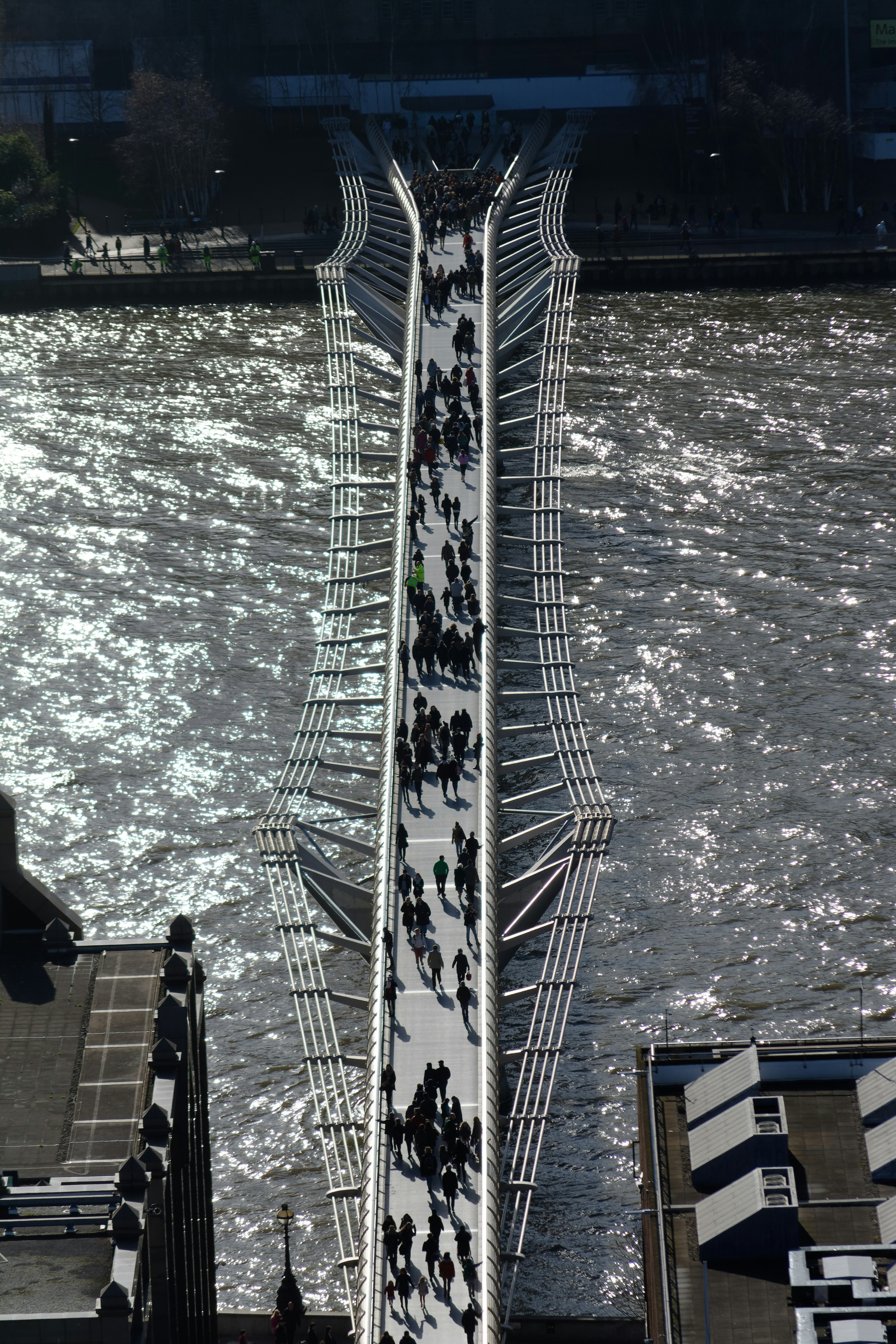 Crowd Crossing the Double-Arched Riverside Bridge (Aerial View)