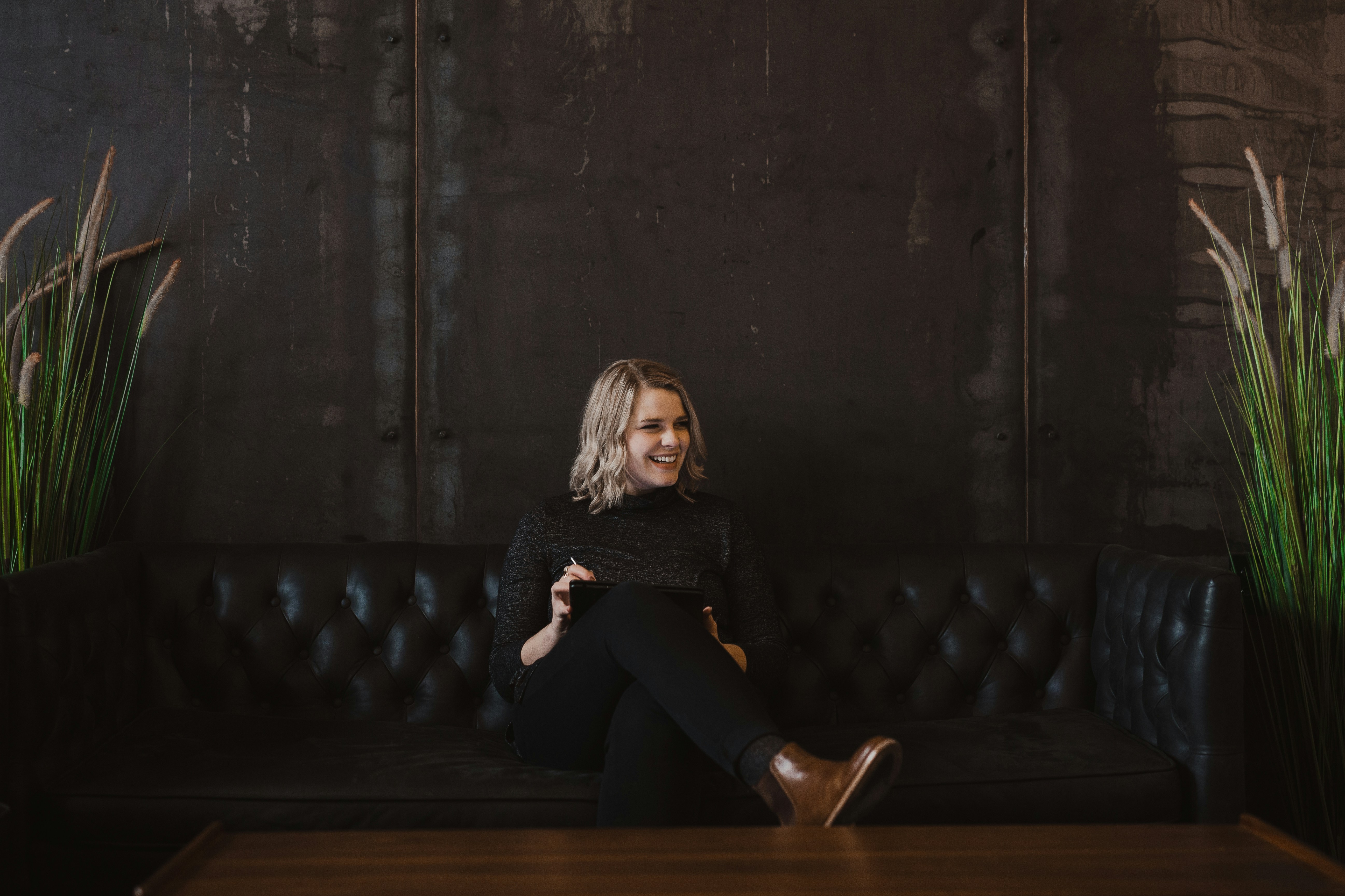 Woman sitting on black leather sofa photo – Free Couch Image on Unsplash