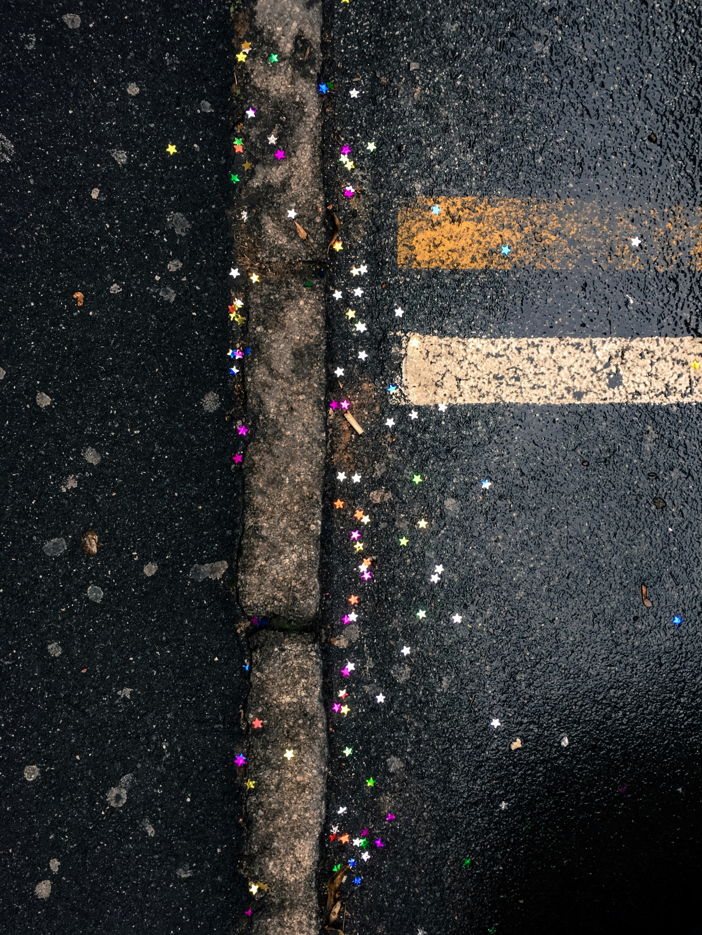 Confetti Constellation Along a Rain-Kissed Curb