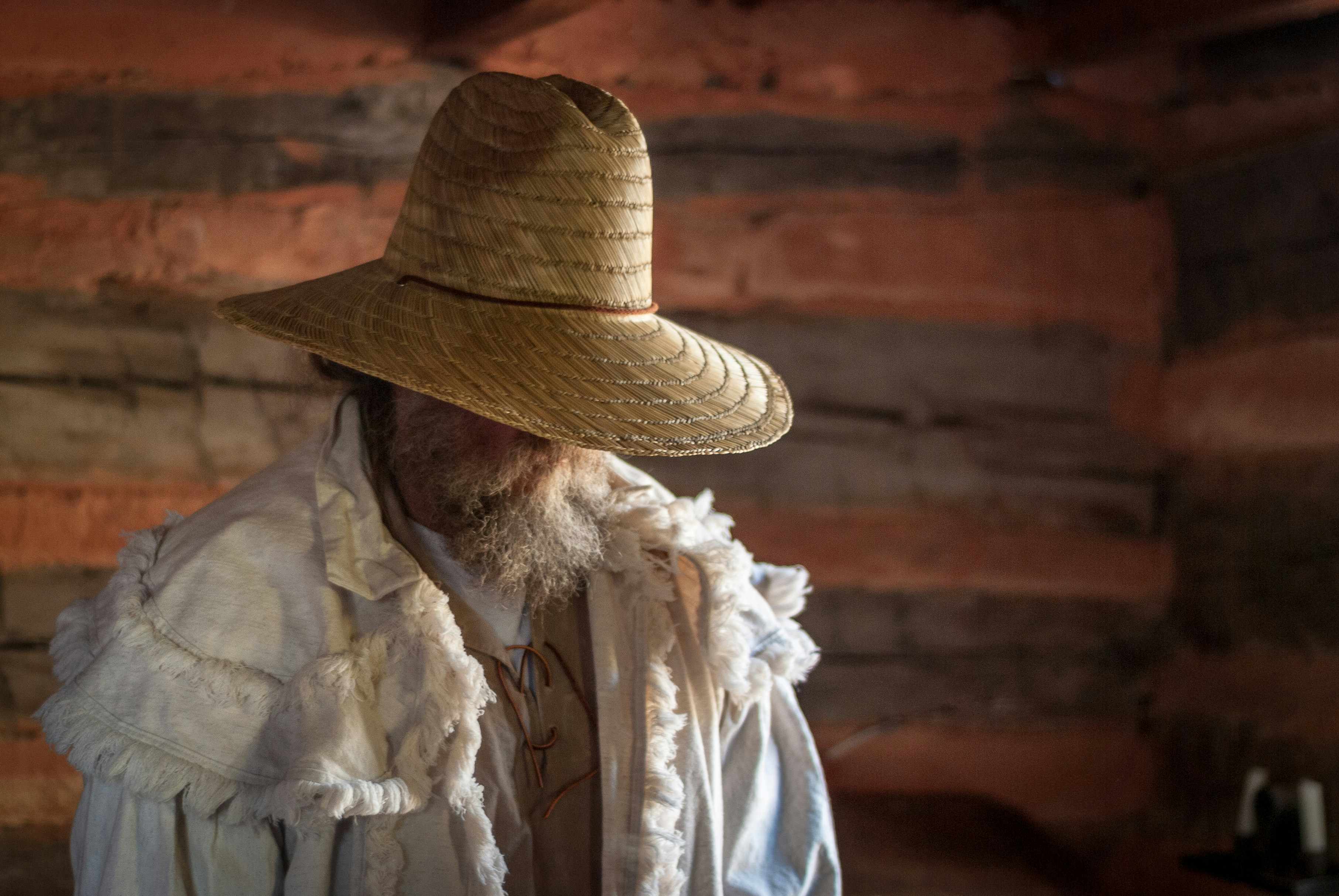 Harvest Day celebration at the local museum; where several times a year they operate a settler’s farm as it might have been run a couple centuries ago. This actor is one of the many figures who work around the wilderness farm for the day, doing tasks as they might have been done in the late 1700’s. | person wearing brown hat