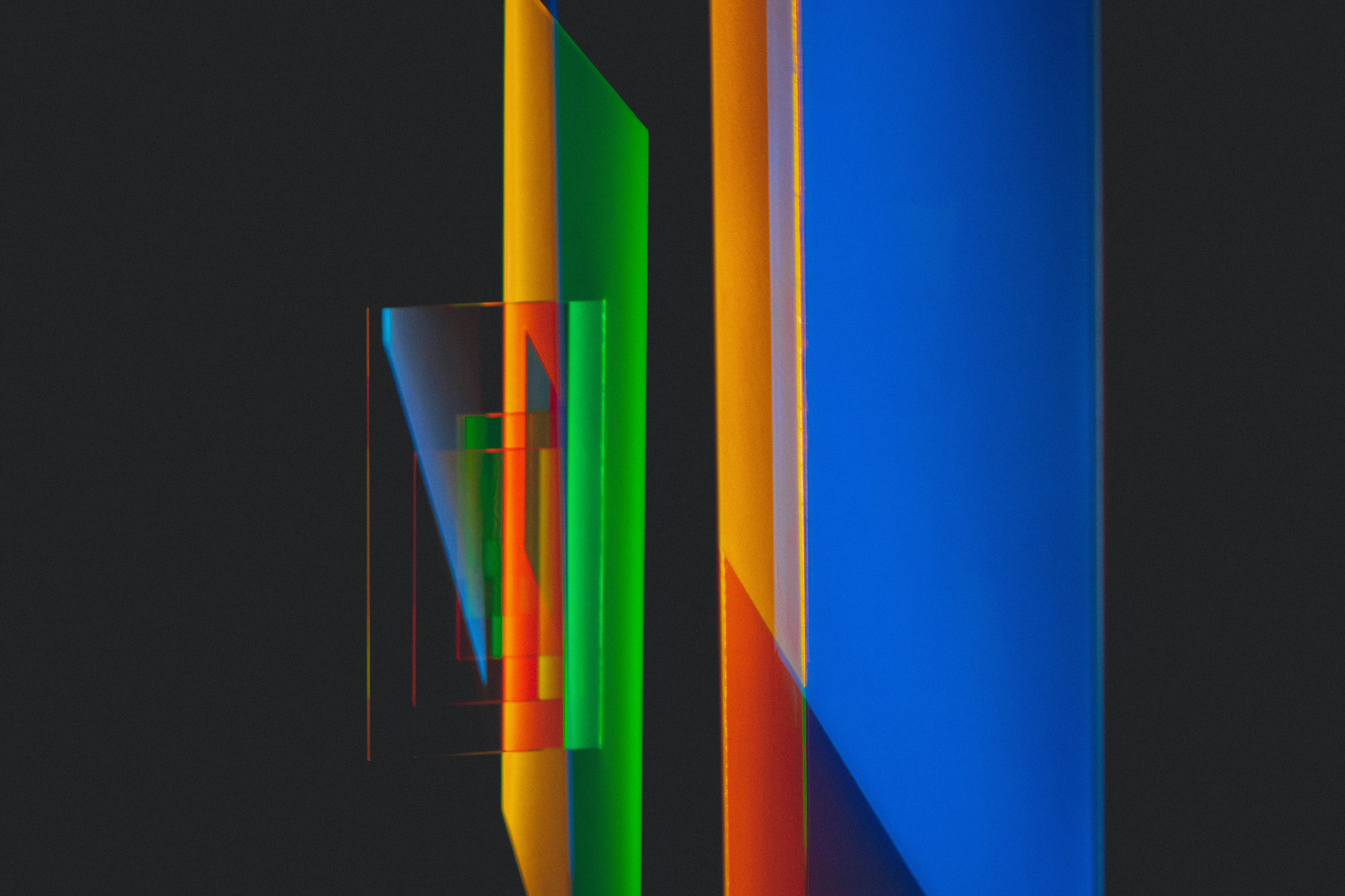 Geometric shapes in vivid colors against a dark background, creating an abstract composition.