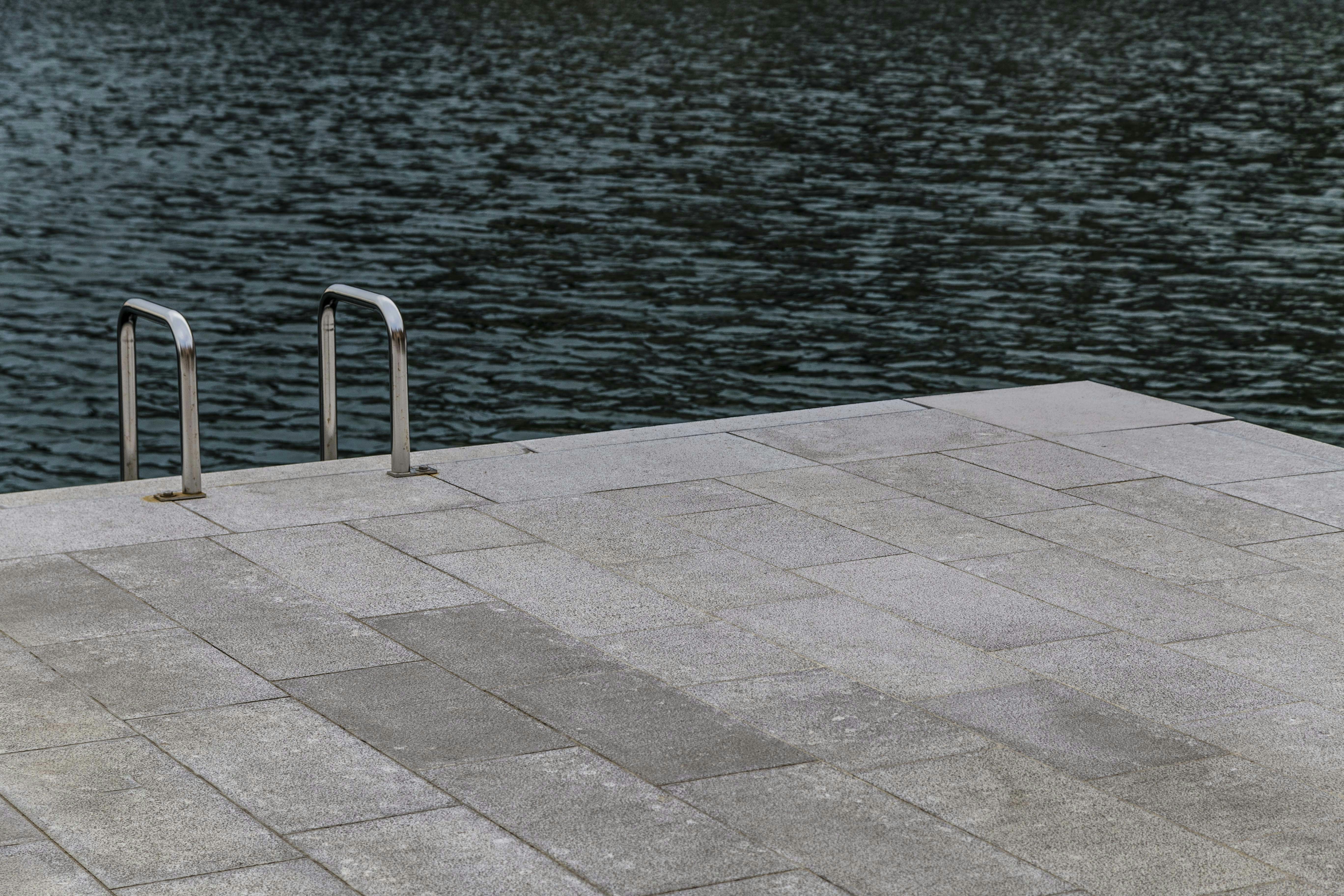 Quiet Dock Edges: Steel Rungs and Concrete Tiles by the Water
