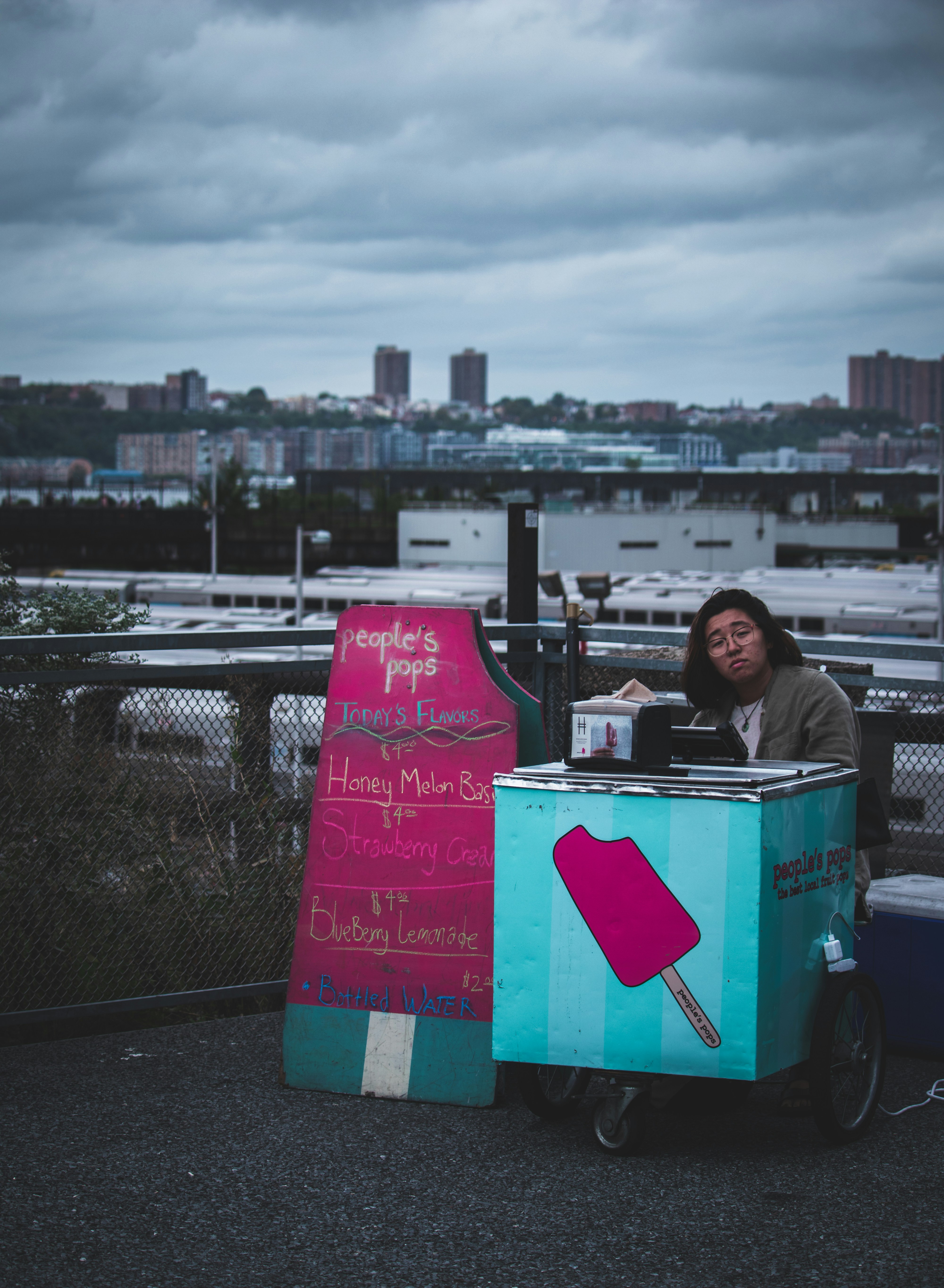 Teal Pops Cart Beneath a Cloudy Skyline: A Quiet Street Moment