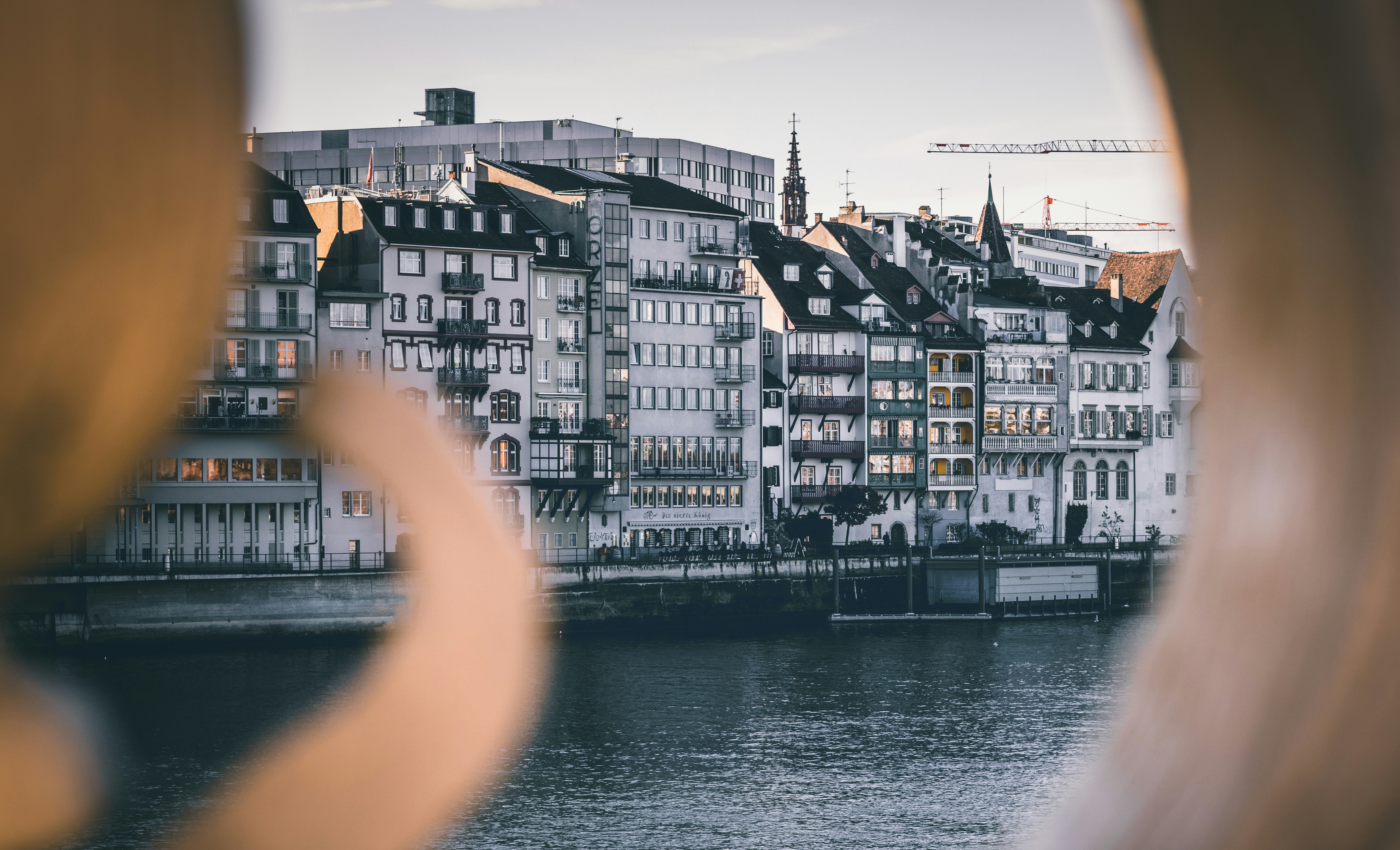 High-rise buildings along a riverside framed by blurred archways.