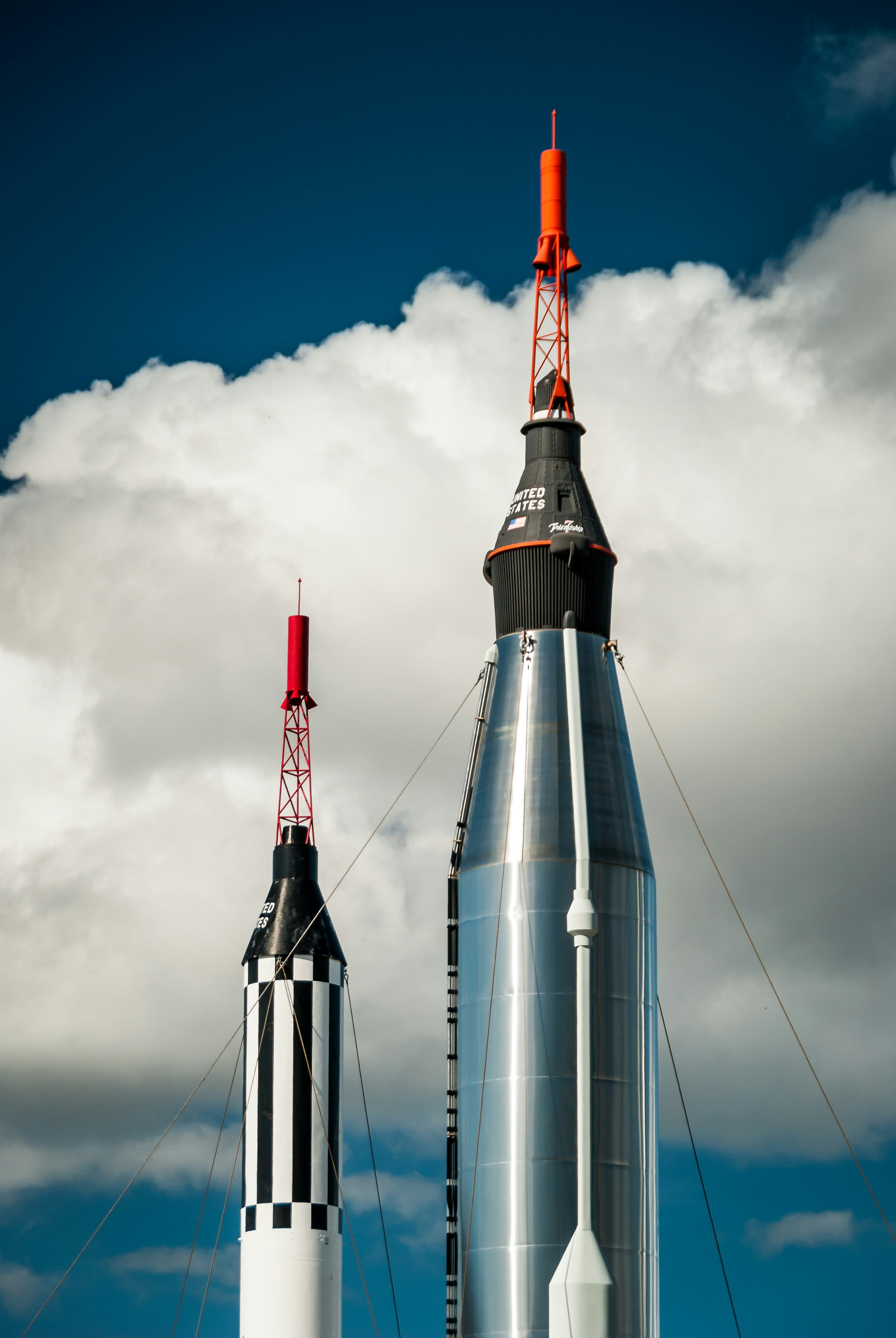 Two iconic rockets stand tall against a backdrop of fluffy clouds, showcasing the journey of American space exploration.