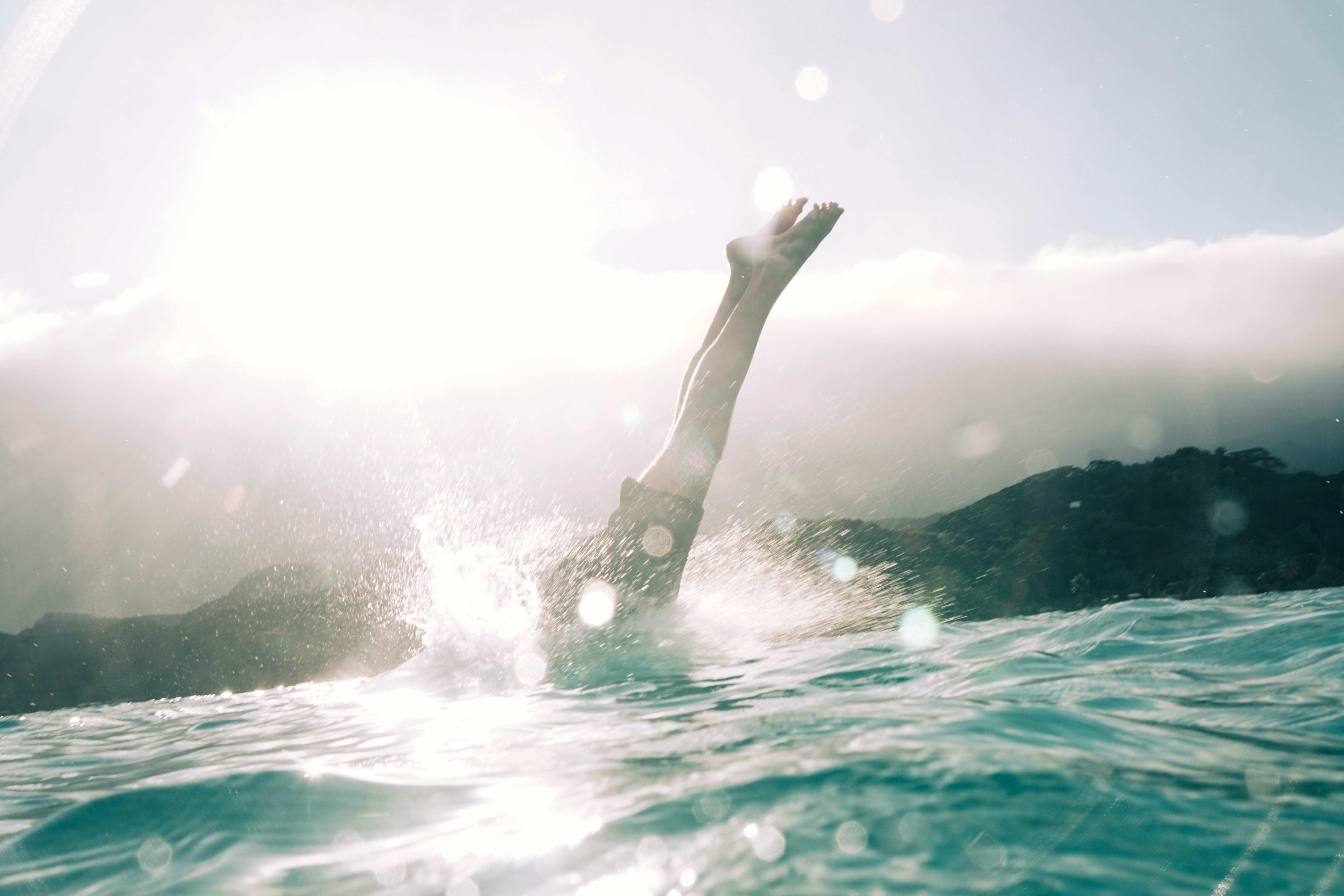 Person diving on body of water during daytime photo – Free White Image ...