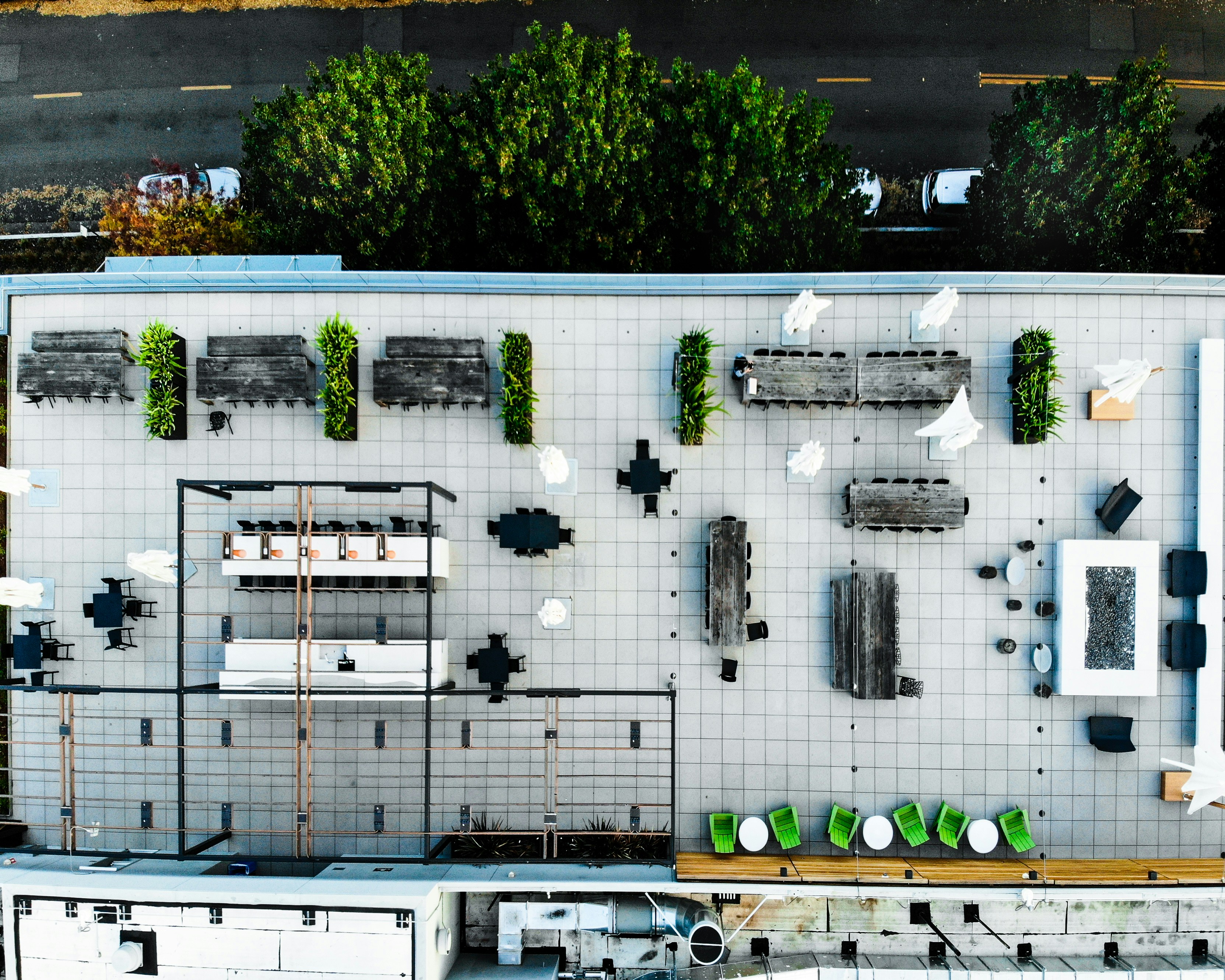Aerial view of a modern rooftop garden with seating areas and greenery.