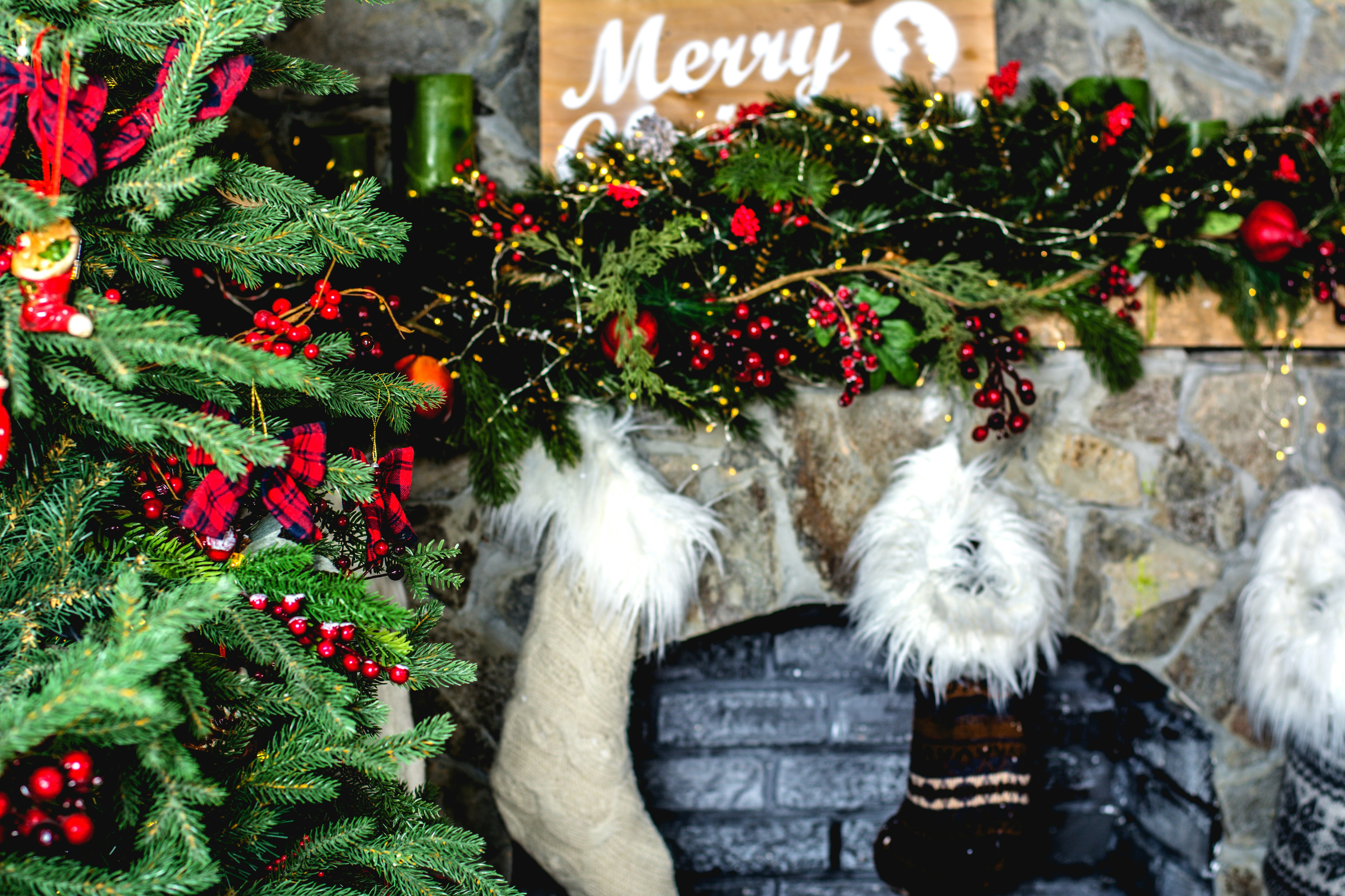 Festive Mantle in Full Bloom: Garland, Stockings, and a Merry Sign