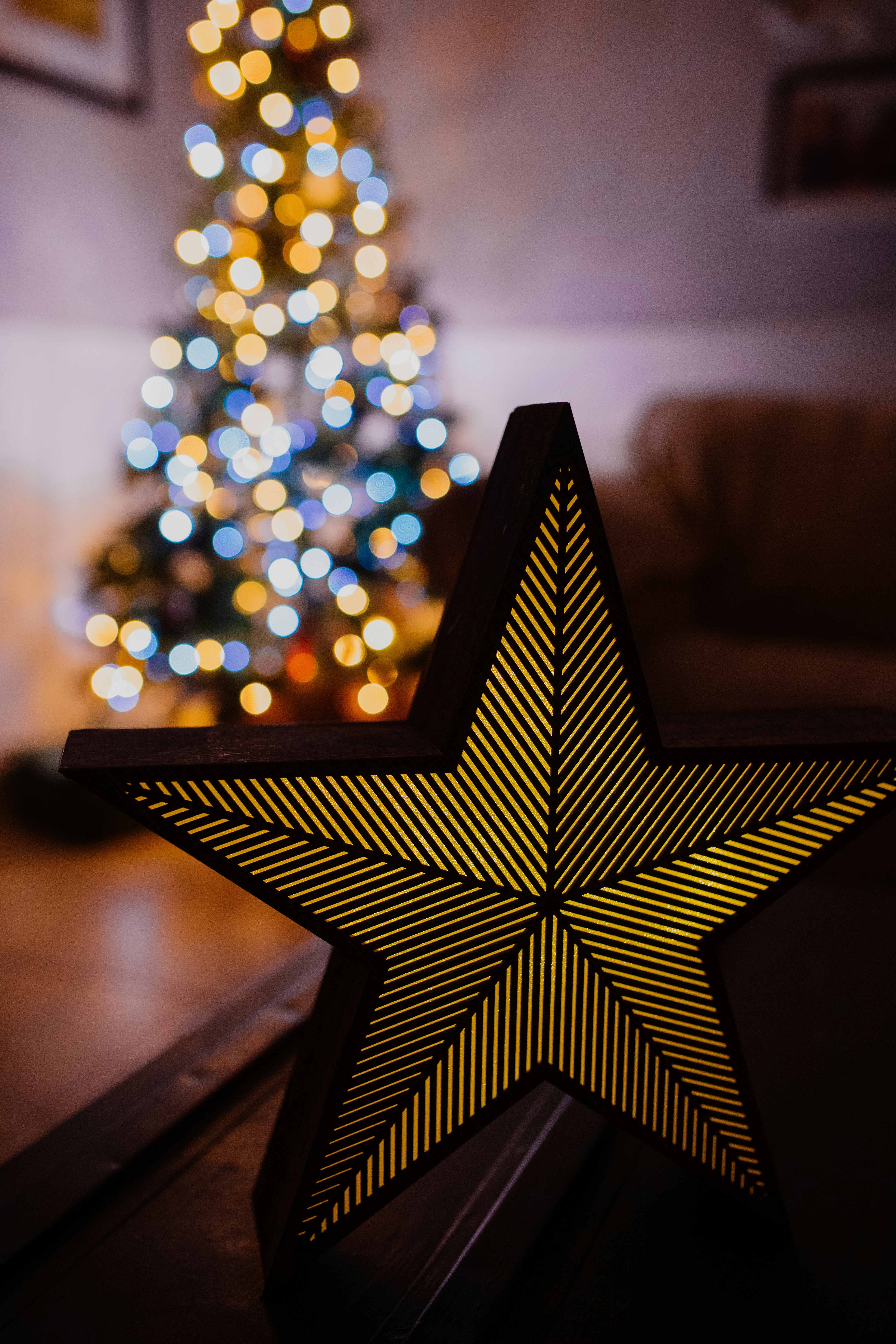 A Christmas star | gold and black star near lit Christmas tree