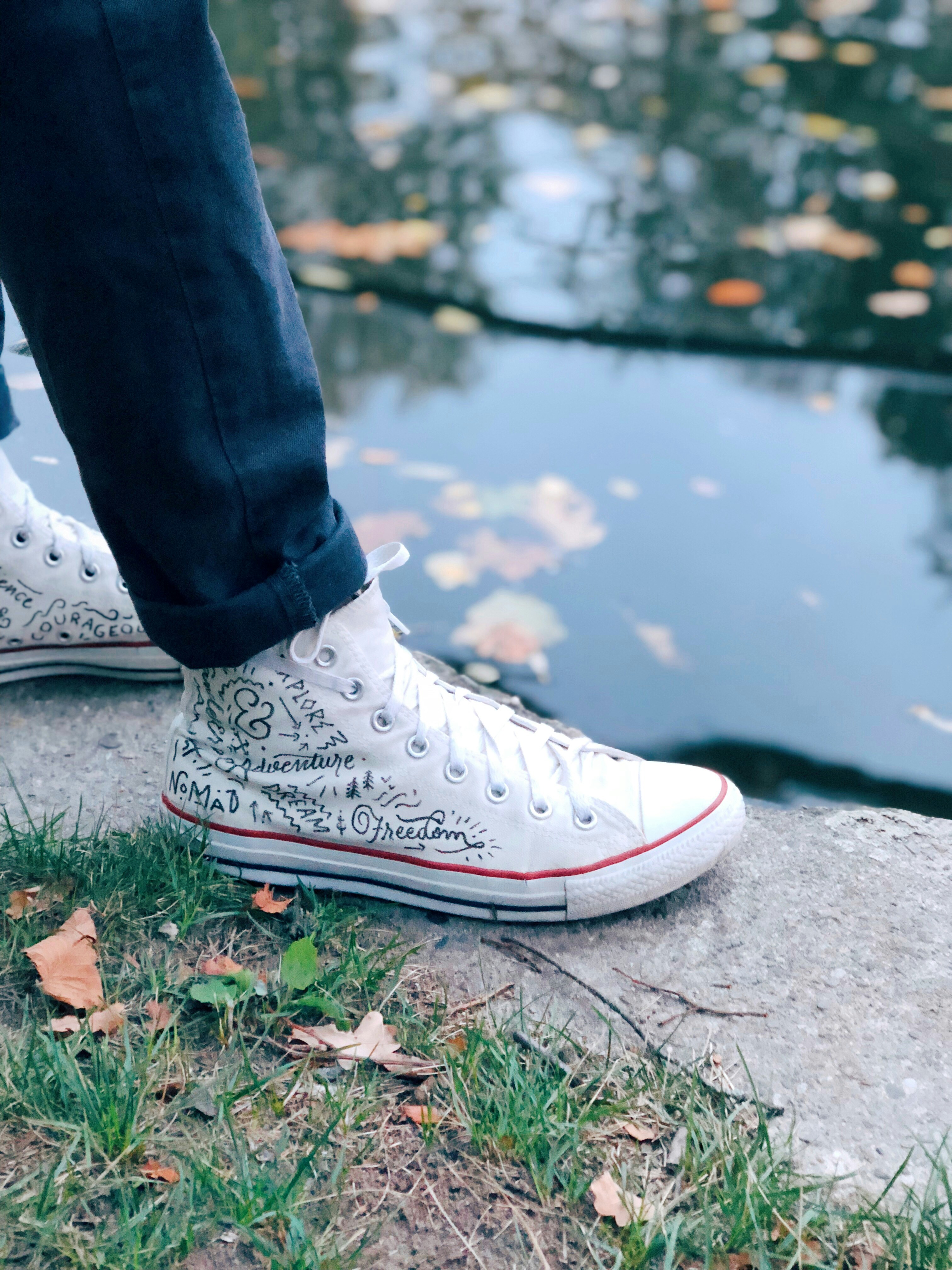 Casual Steps: White Converse on the Edge of a Reflective Pond