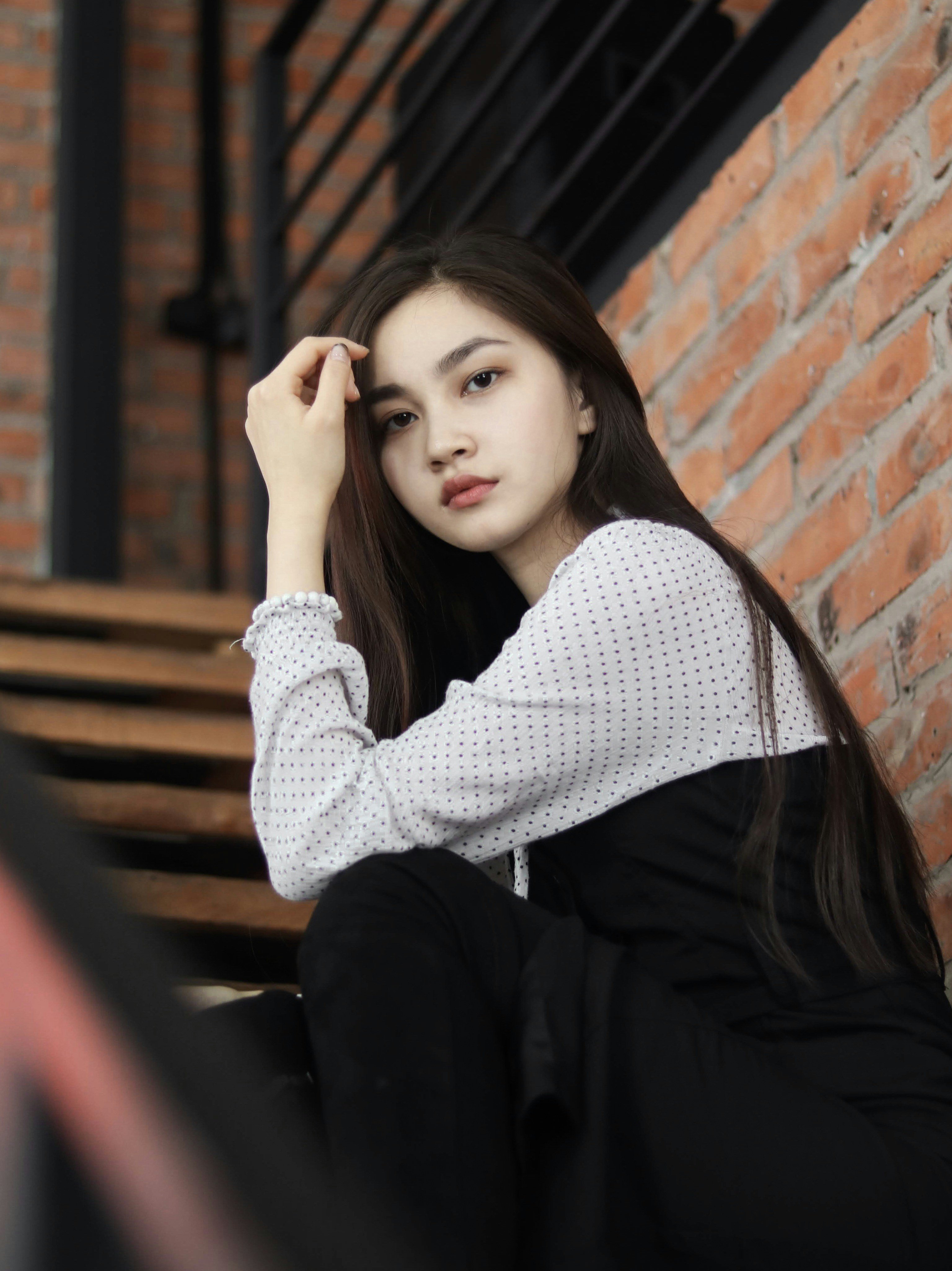 Mujer con top blanco y negro sentada en la escalera foto – Imagen de Atavío gratuita en Unsplash