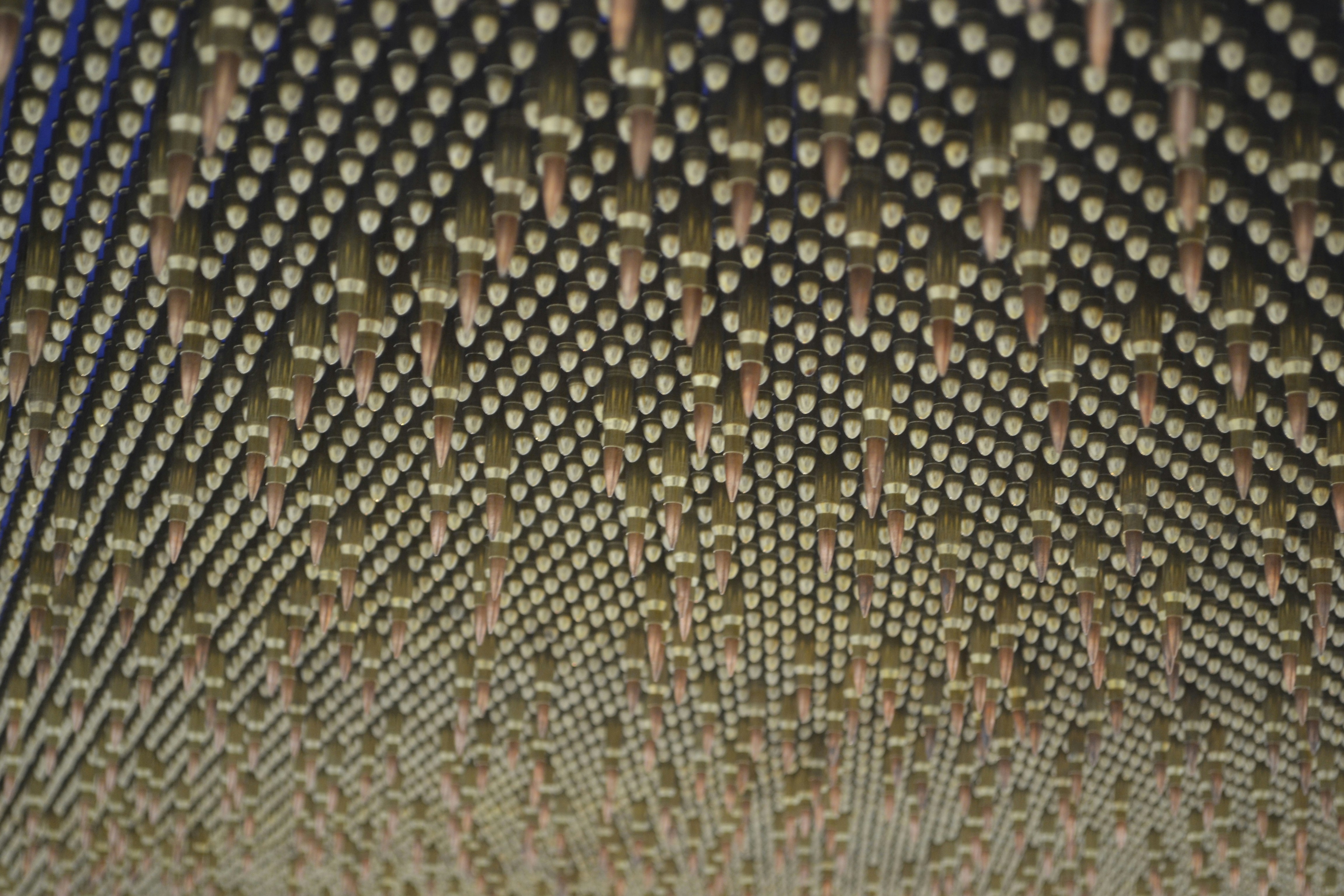 Close-up view of a meticulously arranged array of metallic objects, showcasing their geometric patterns and textures.