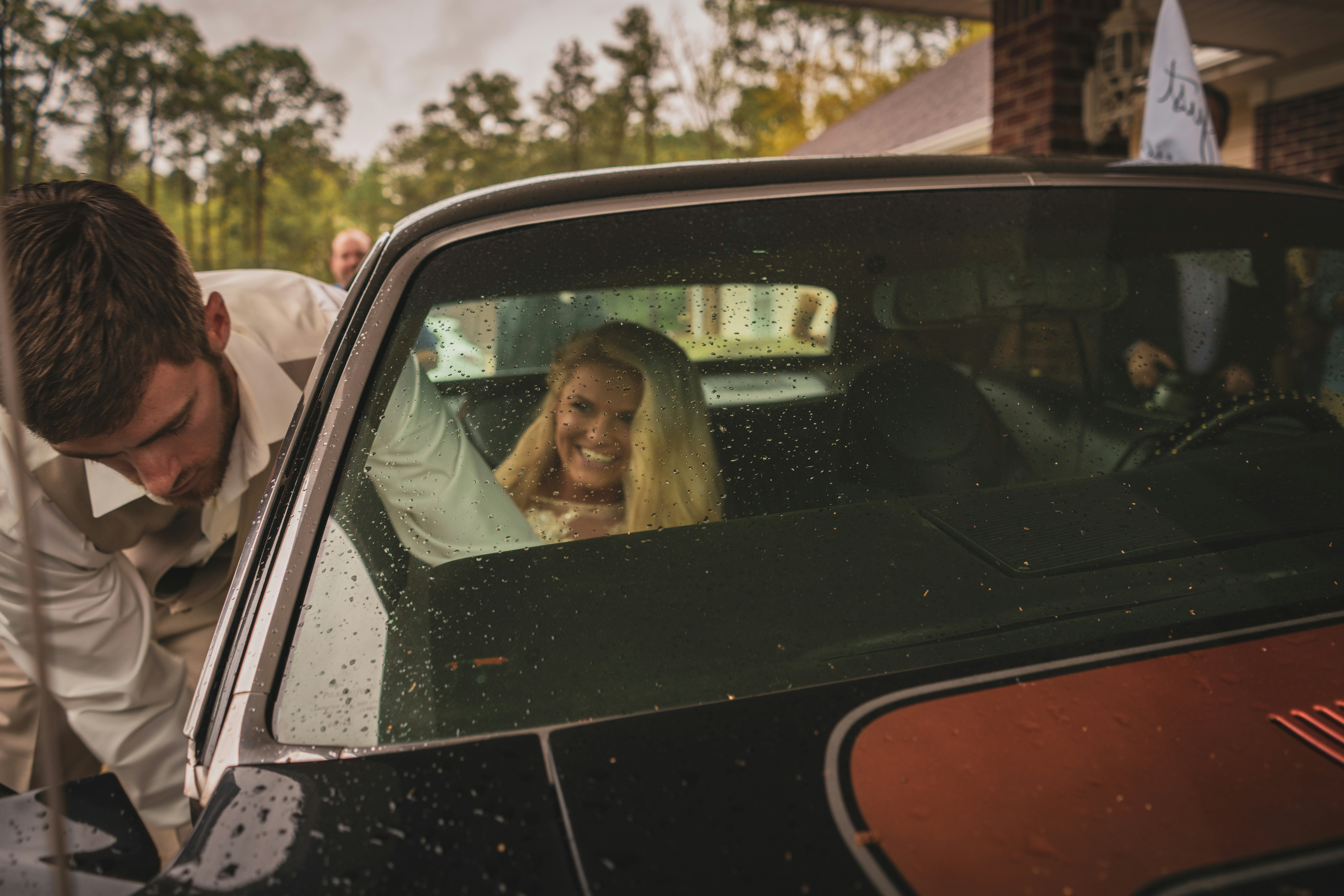 Bride Laughs Through Car Window After Rainy Wedding Exit