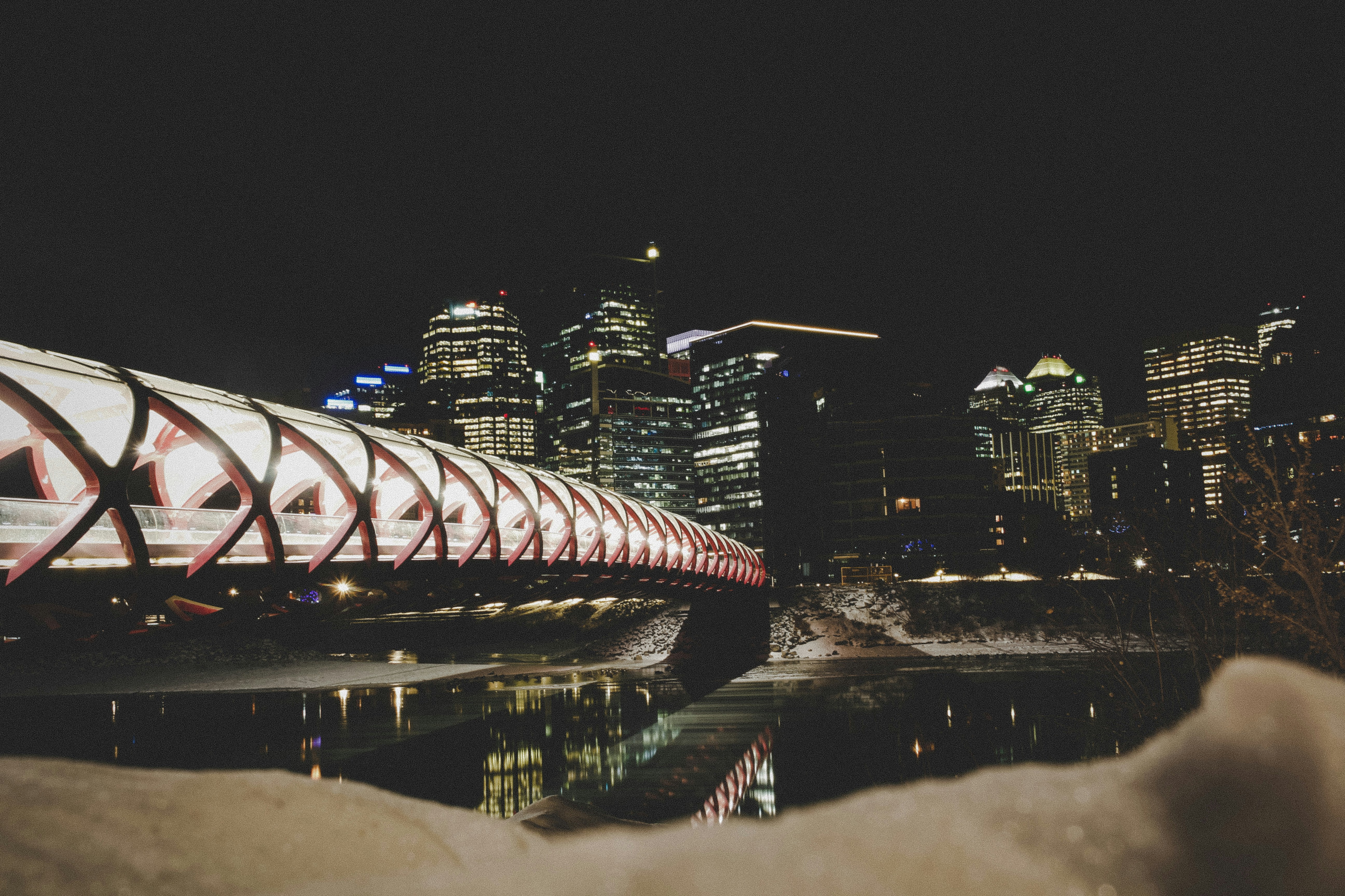 Crimson Ribbon Over Snow: A Night Bridge Framing the City's Glow