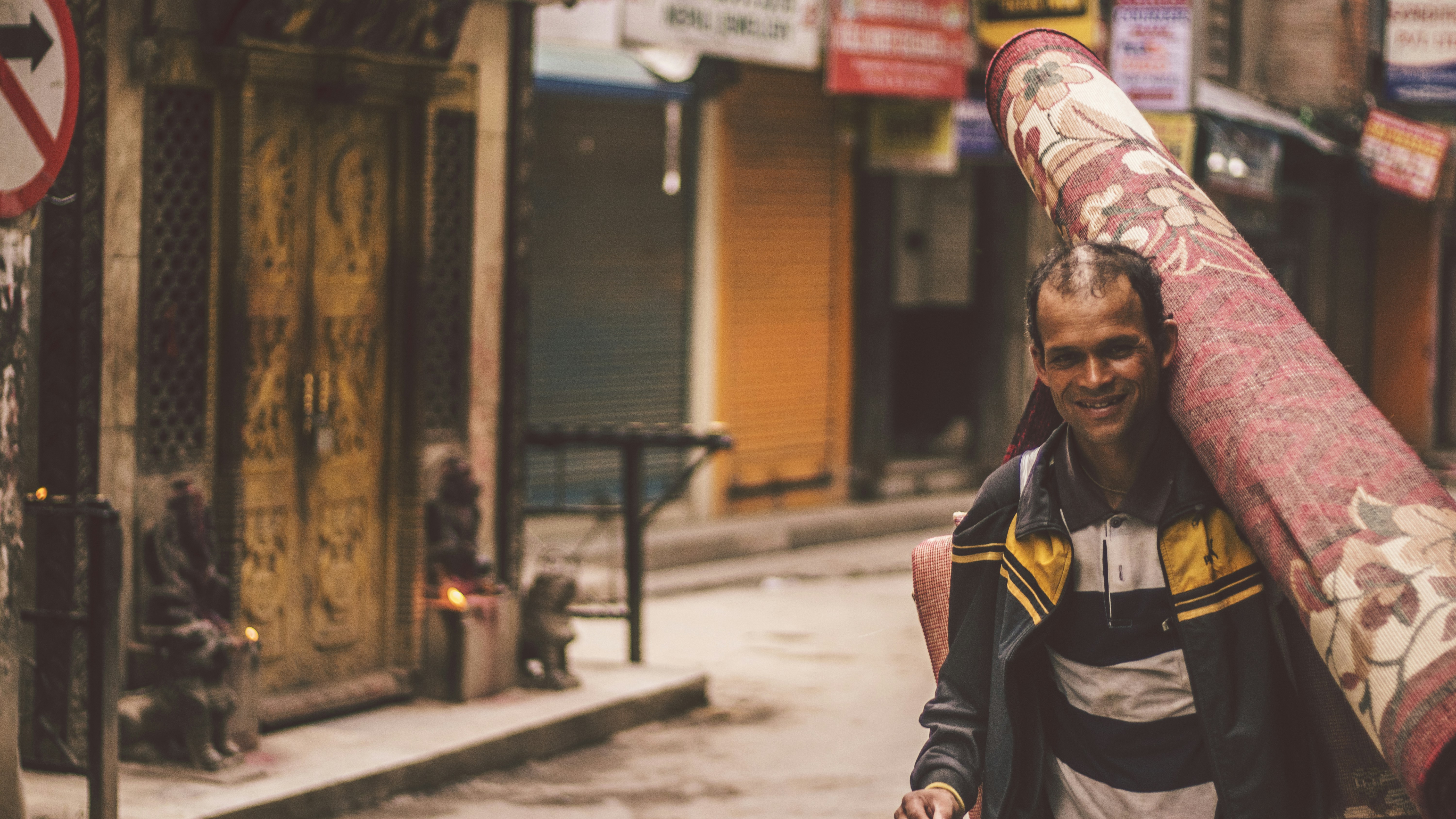 Smiling man carrying carpet photo – Free Human Image on Unsplash