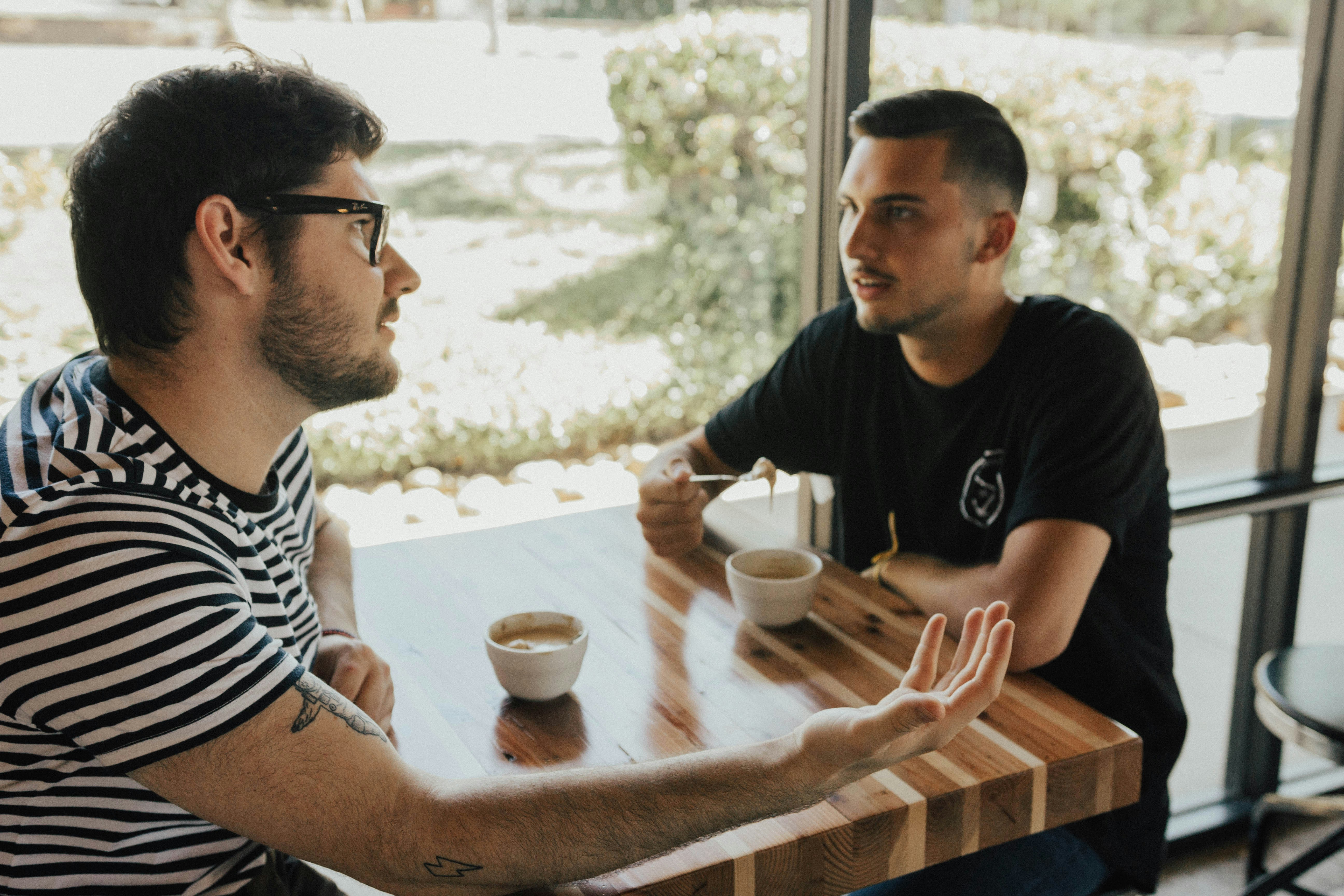 Two men having conversation on table photo – Free Food Image on Unsplash