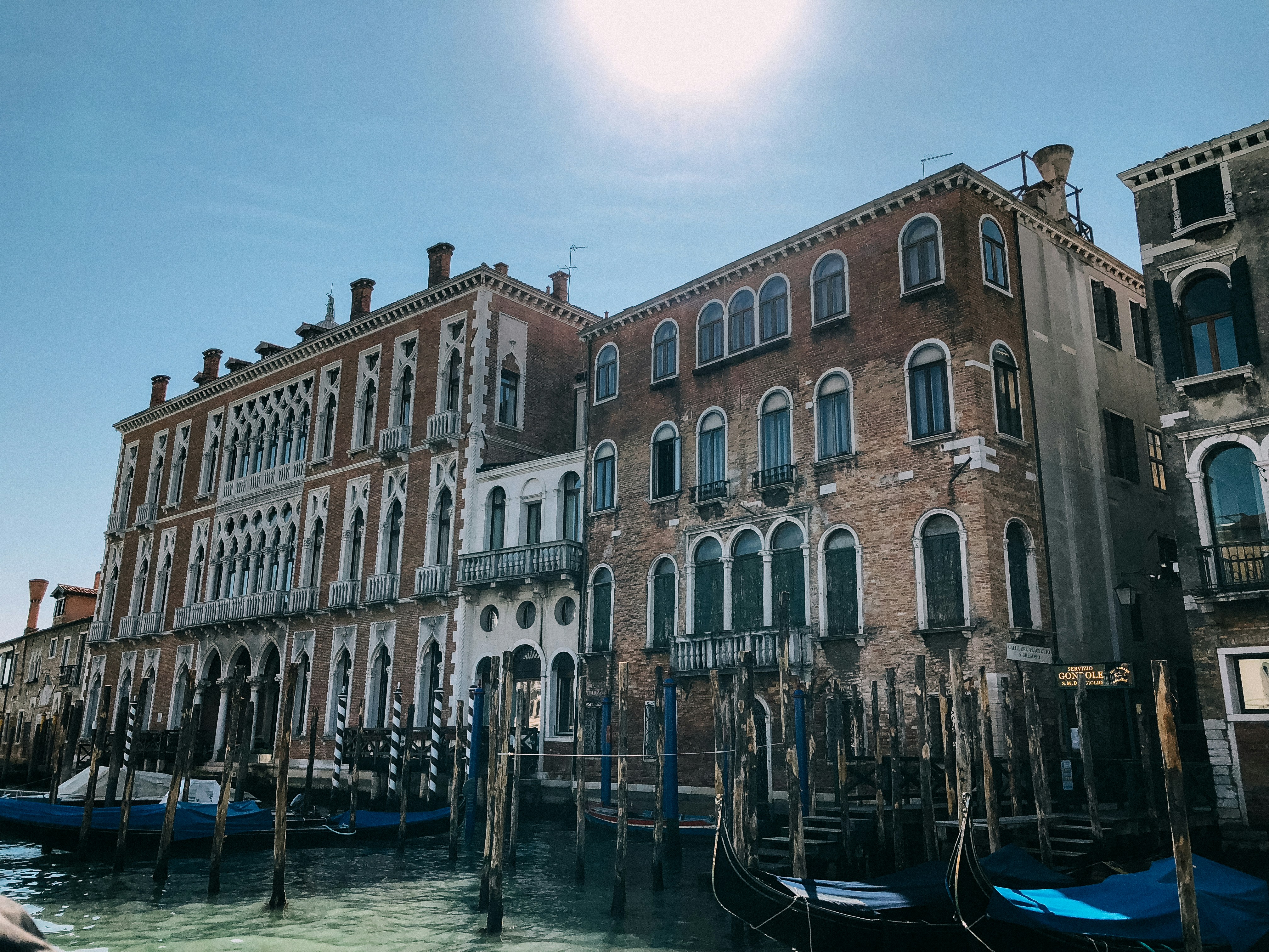 Historic buildings lining the canals of Venice, showcasing intricate architectural details and reflections in the water.