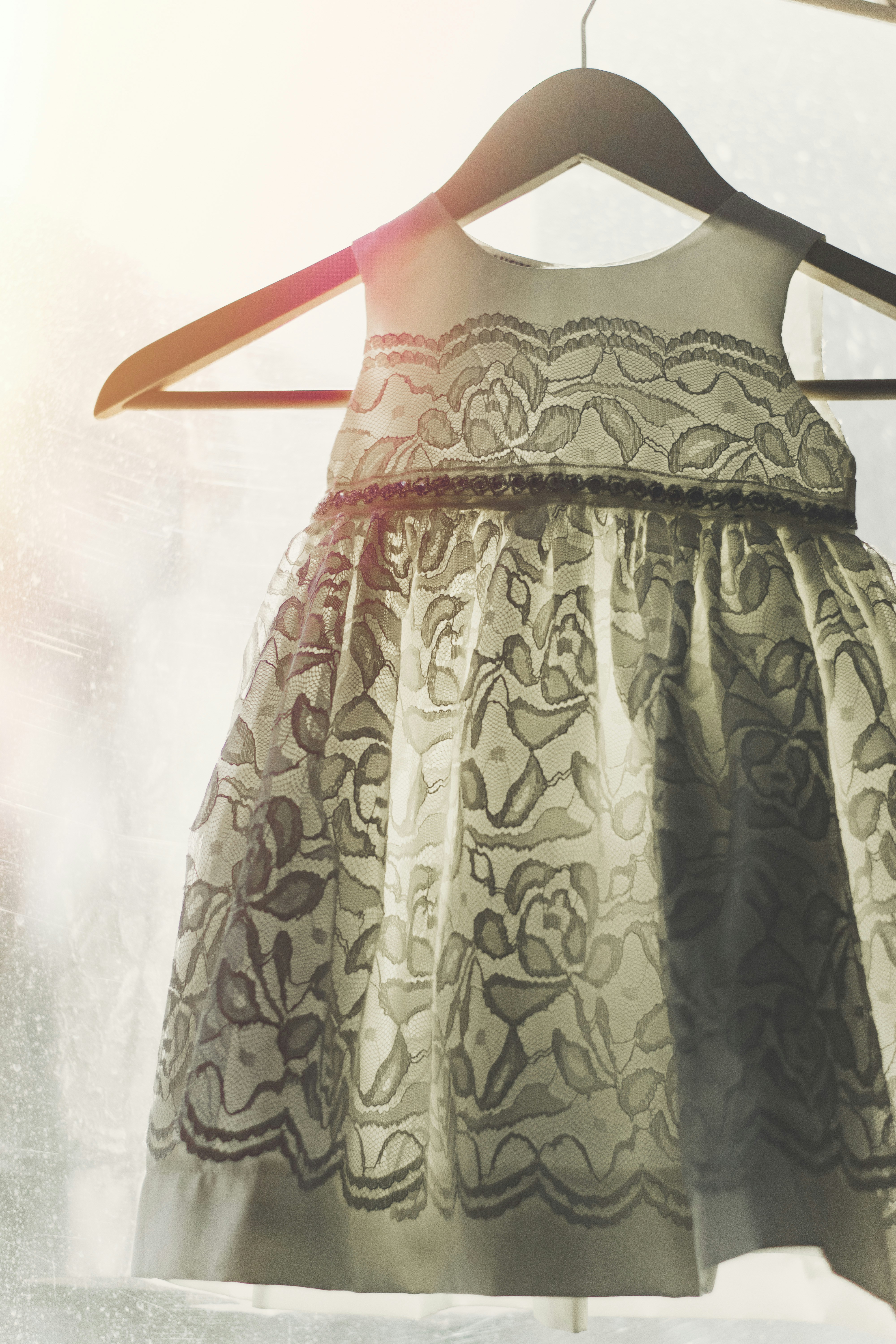 Backlit Lace Reverie: Morning Light Drapes a Delicate Dress on a Hanger