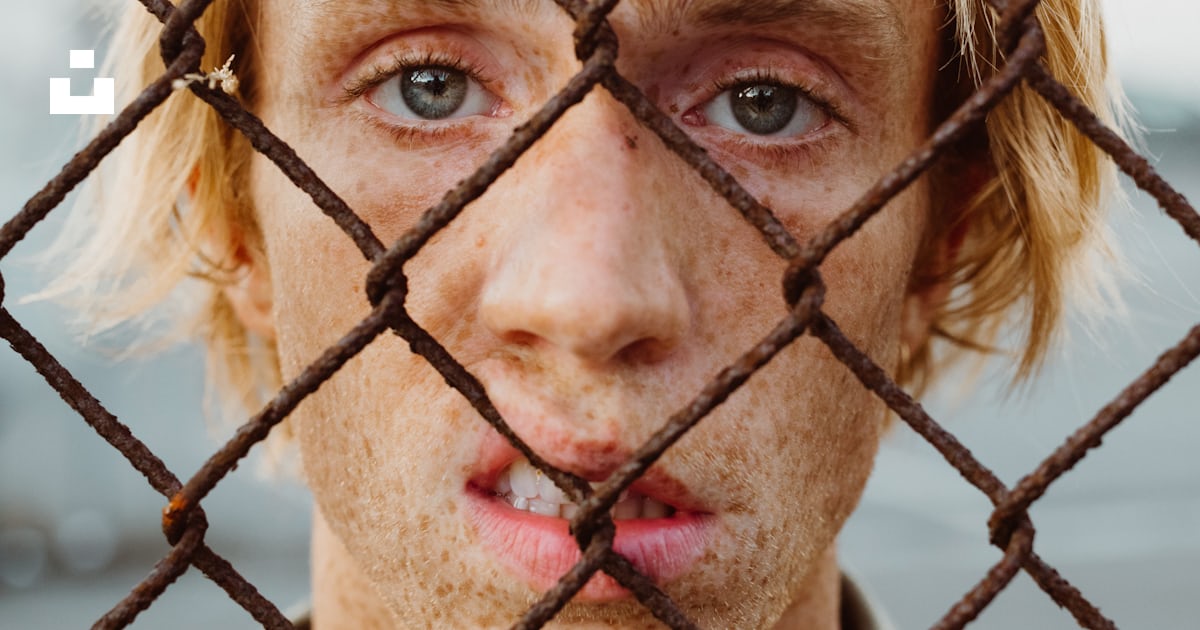 Man In Gray Collared Shirt Standing Behind Chain Link Fence Photo