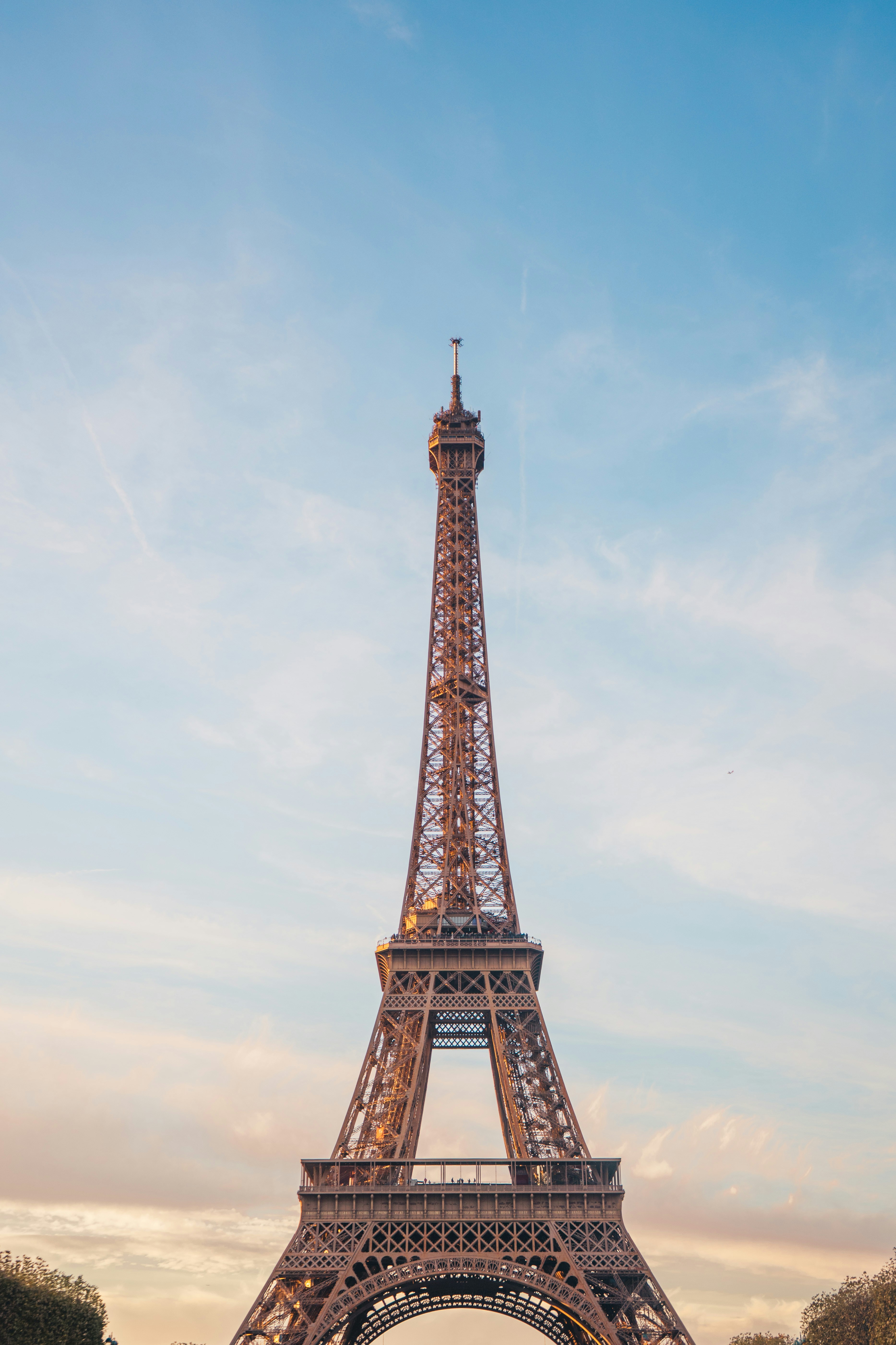Eiffel Tower towering against a pastel sky, showcasing intricate ironwork and architectural elegance.