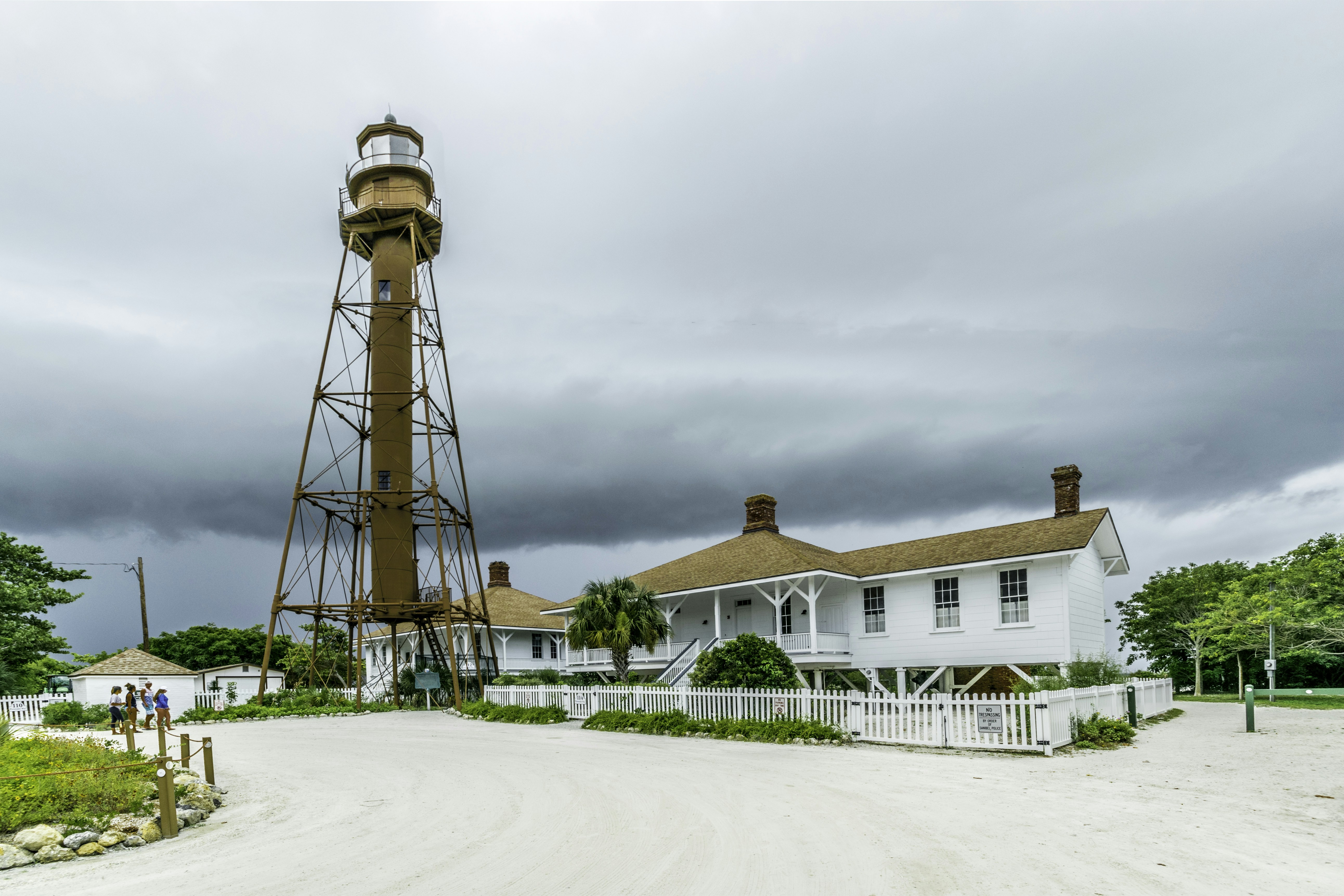 Iron Sentinels by the Coast: A Lighthouse Among White Cottages